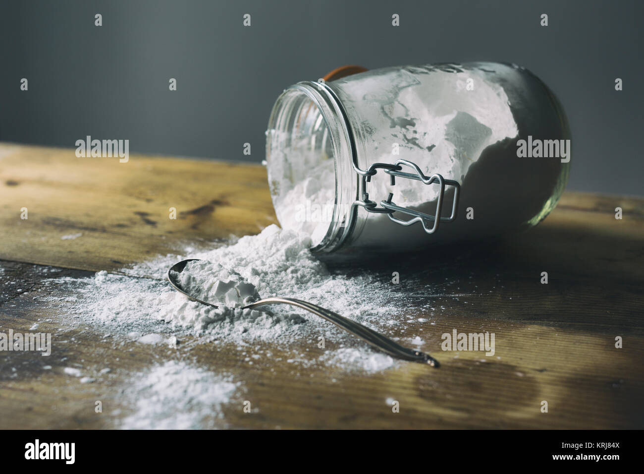 Arrowroot powder spilled on an old wood table. Shown with antique ...
