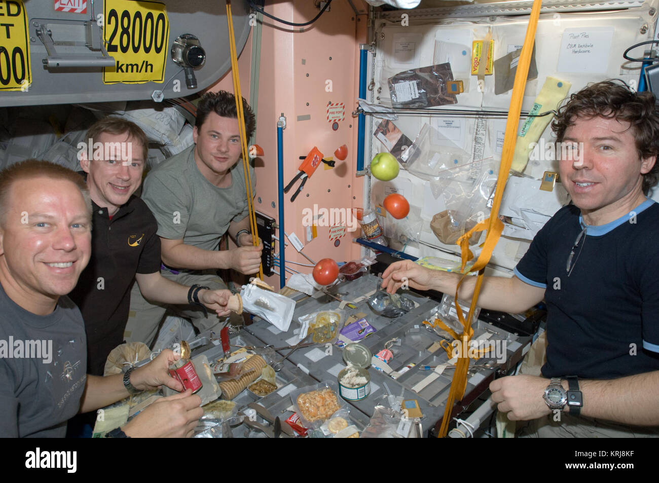 ISS-20 Crew members share a meal at a galley in the Unity node of the ...