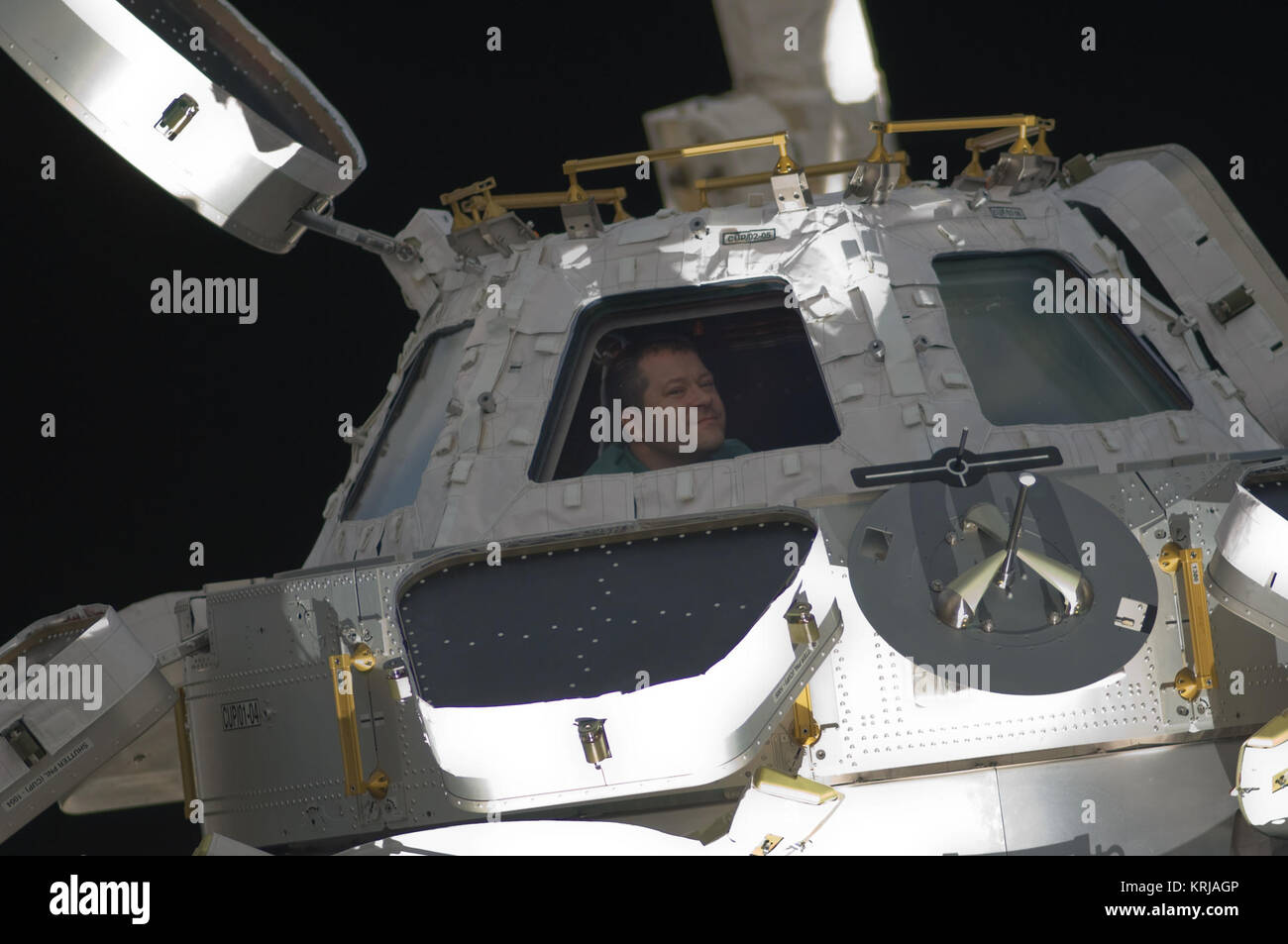 STS-130 Nicholas Patrick looks through Cupola Stock Photo - Alamy