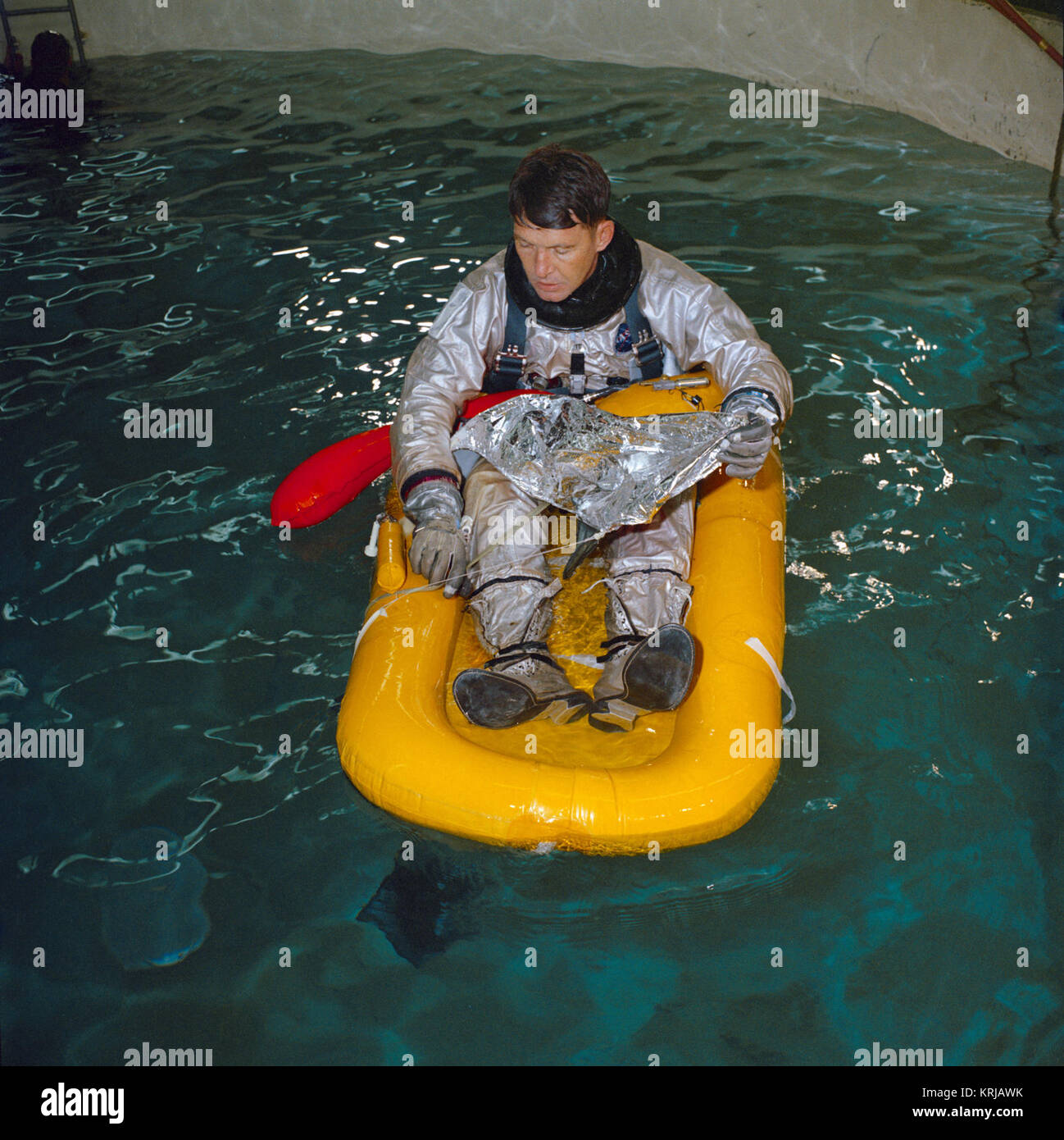 Wally Schirra floats on a one-man life raft during water egress ...