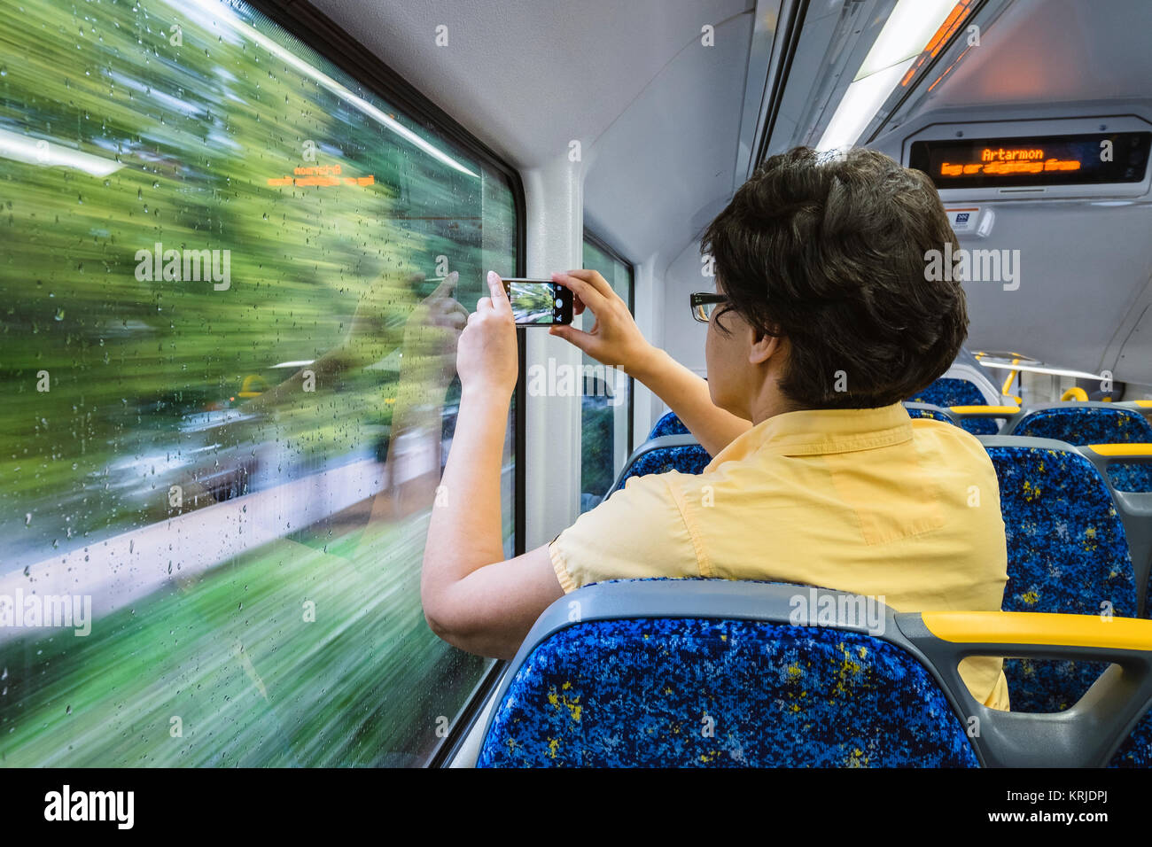 Woman Filming/Photographing from a Window While Travelling on a Train ...