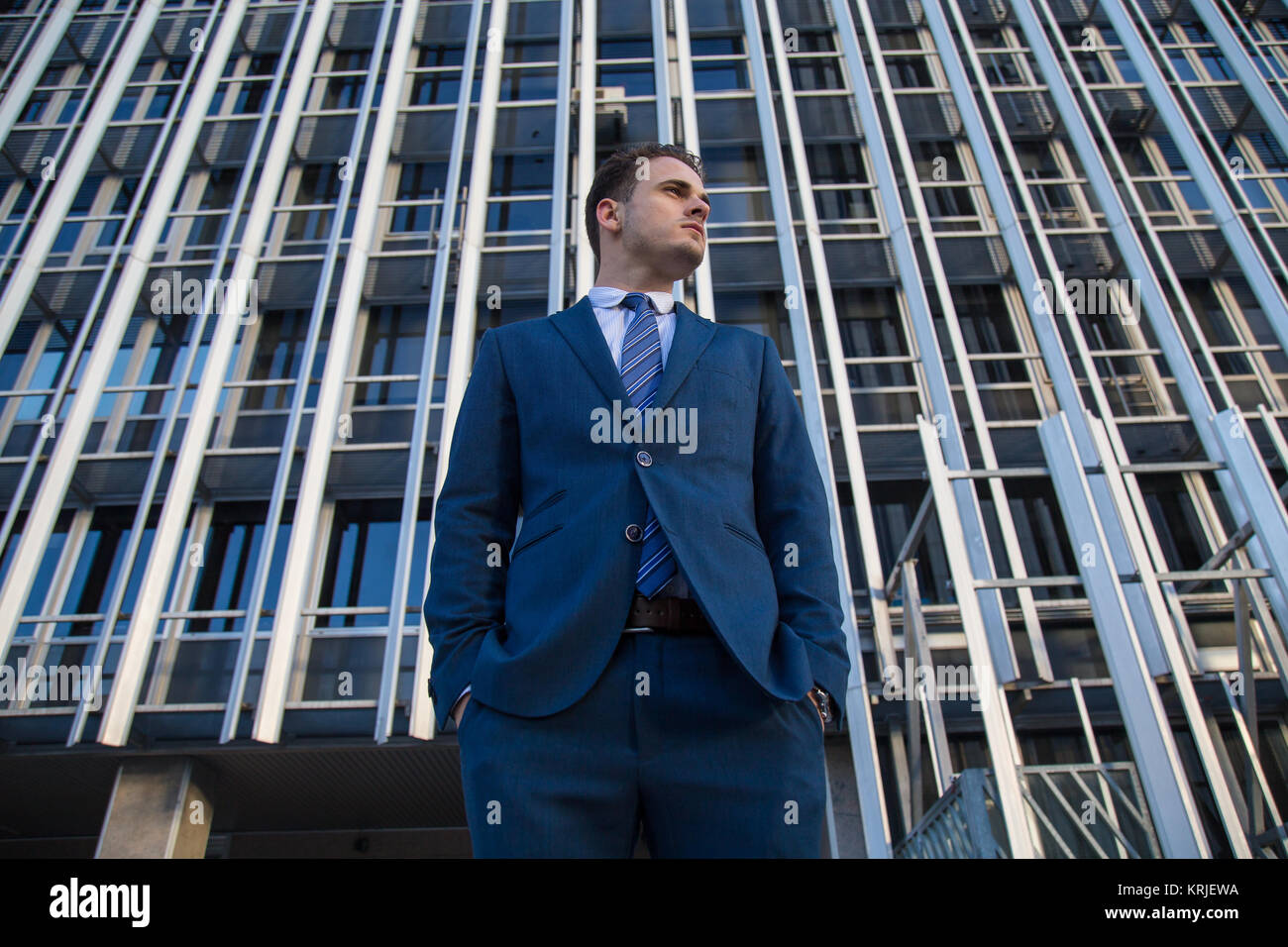 From below view of stylish man in elegant suit posing confidently on ...