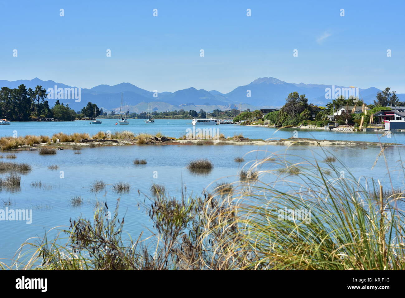 Shallow estuary with recreational vessels anchored on calm water and ...