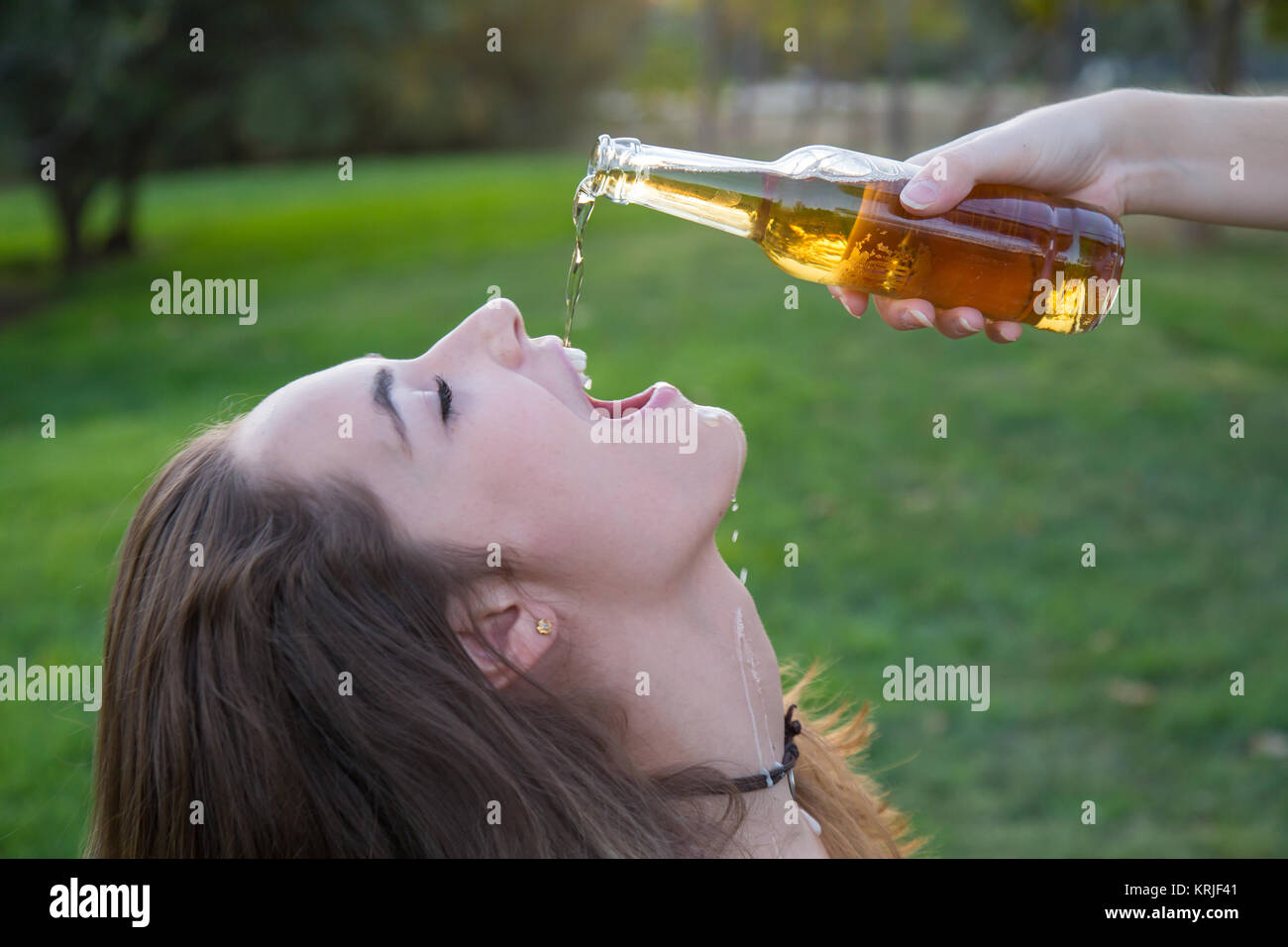 Young woman giving beer to her friend from a bottle Stock Photo - Alamy