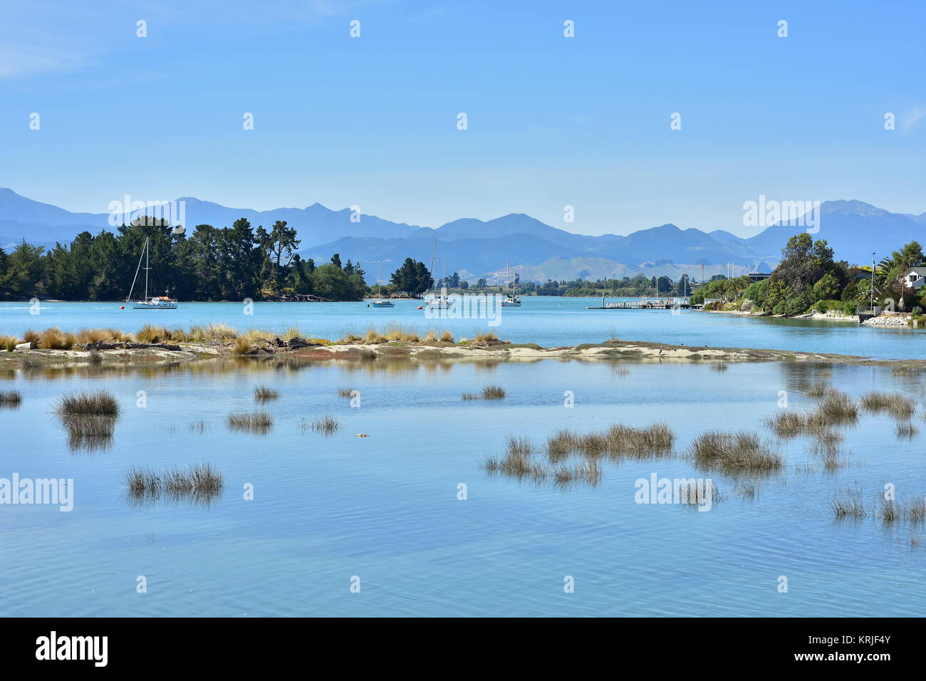 Shallow sandy estuary with calm water and channel between flat island ...