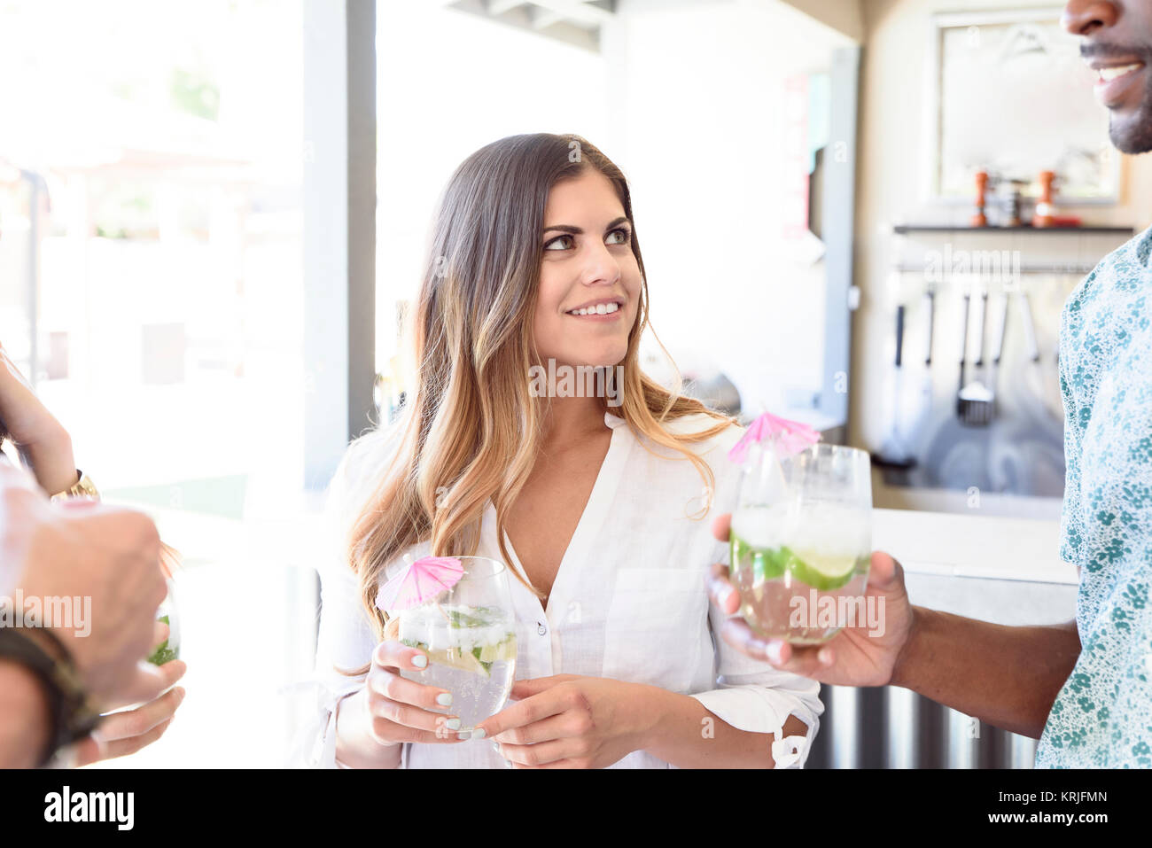Smiling friends with cold drinks talking outdoors Stock Photo - Alamy