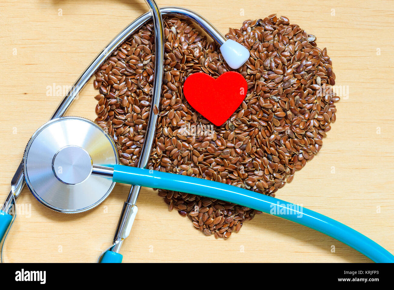 Diet healthcare and checkup concept. Raw flax seeds linseed heart shaped and stethoscope ...