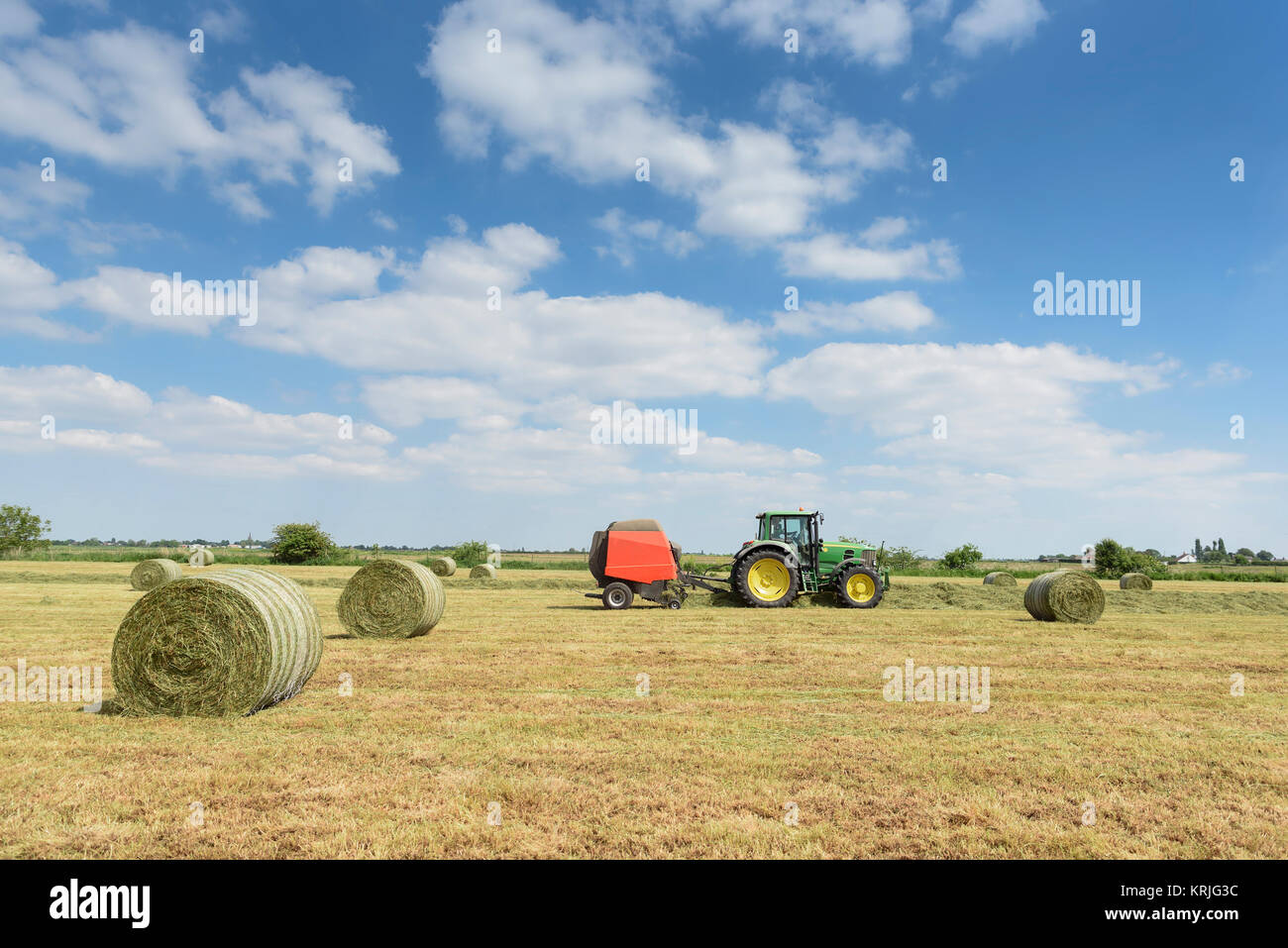 Caucasian man driving tractor baling hay Stock Photo - Alamy