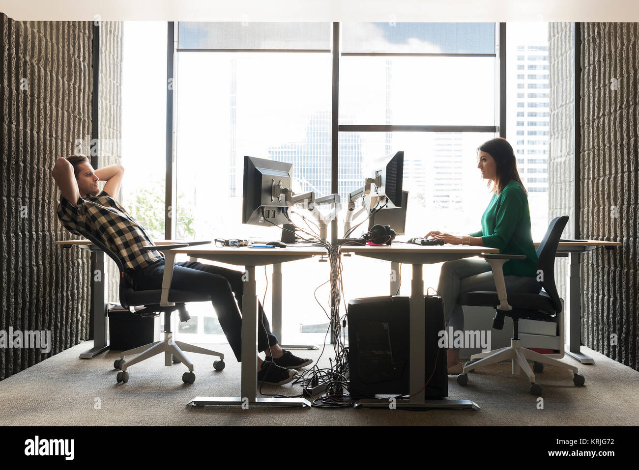 Caucasian man and woman using computers in office Stock Photo - Alamy