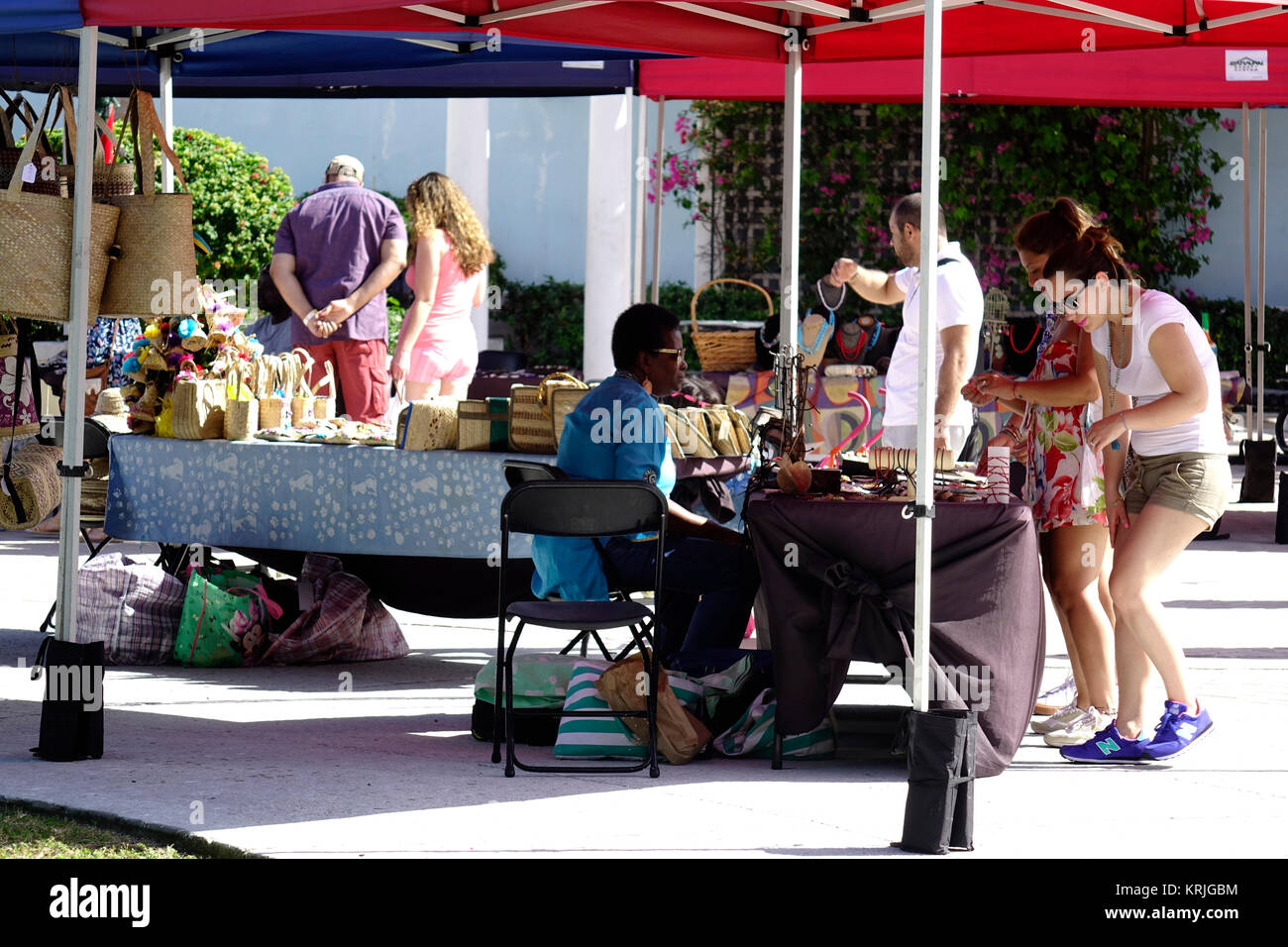 Two female shoppers check out a vendors goods in an open air market in ...