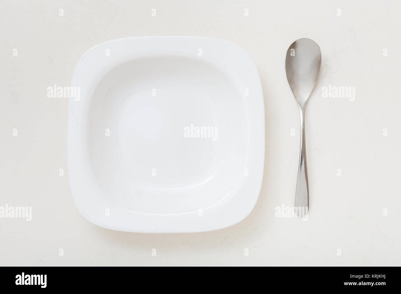 top view of square white bowl and spoon on plaster Stock Photo - Alamy