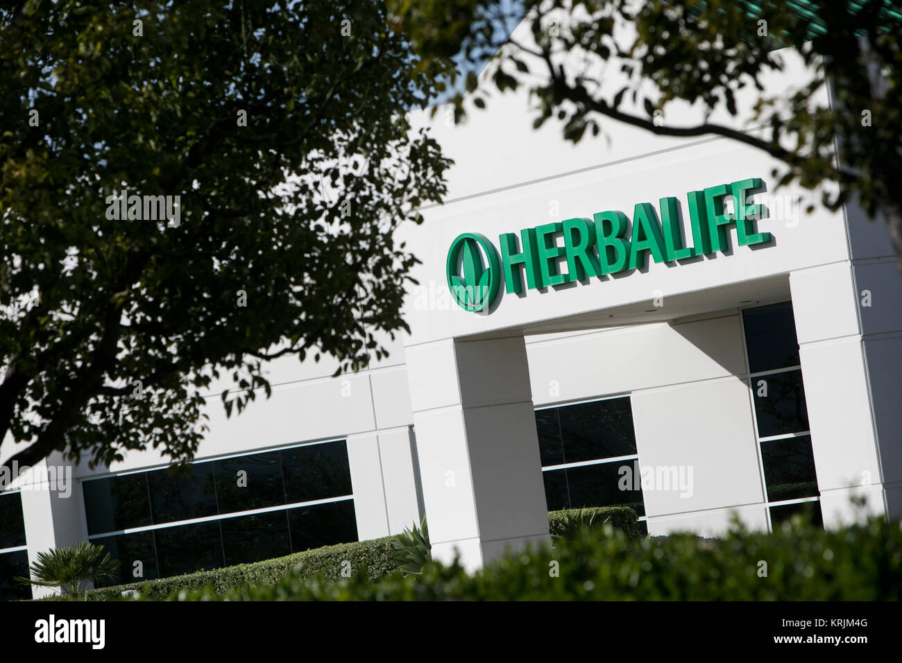 A logo sign outside of a facility occupied by Herbalife International ...
