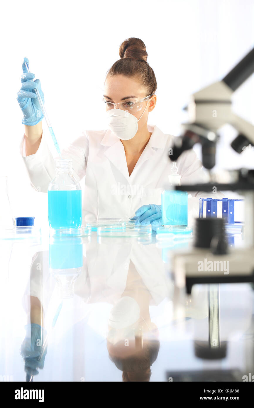 chemist examine the sample under a microscope Stock Photo - Alamy