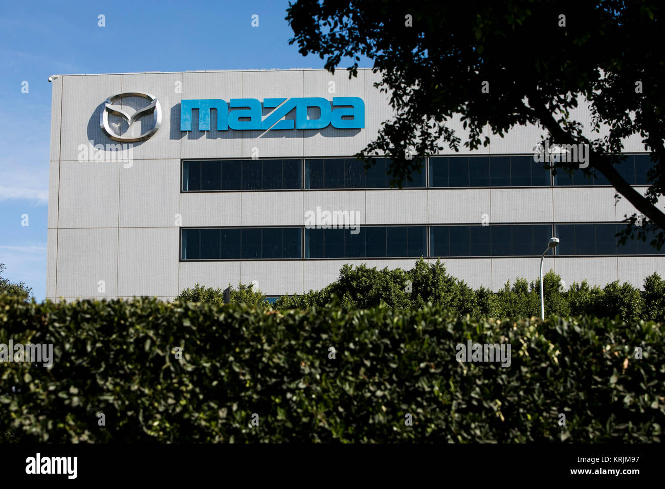 A logo sign outside of a facility occupied by the Mazda Motor ...