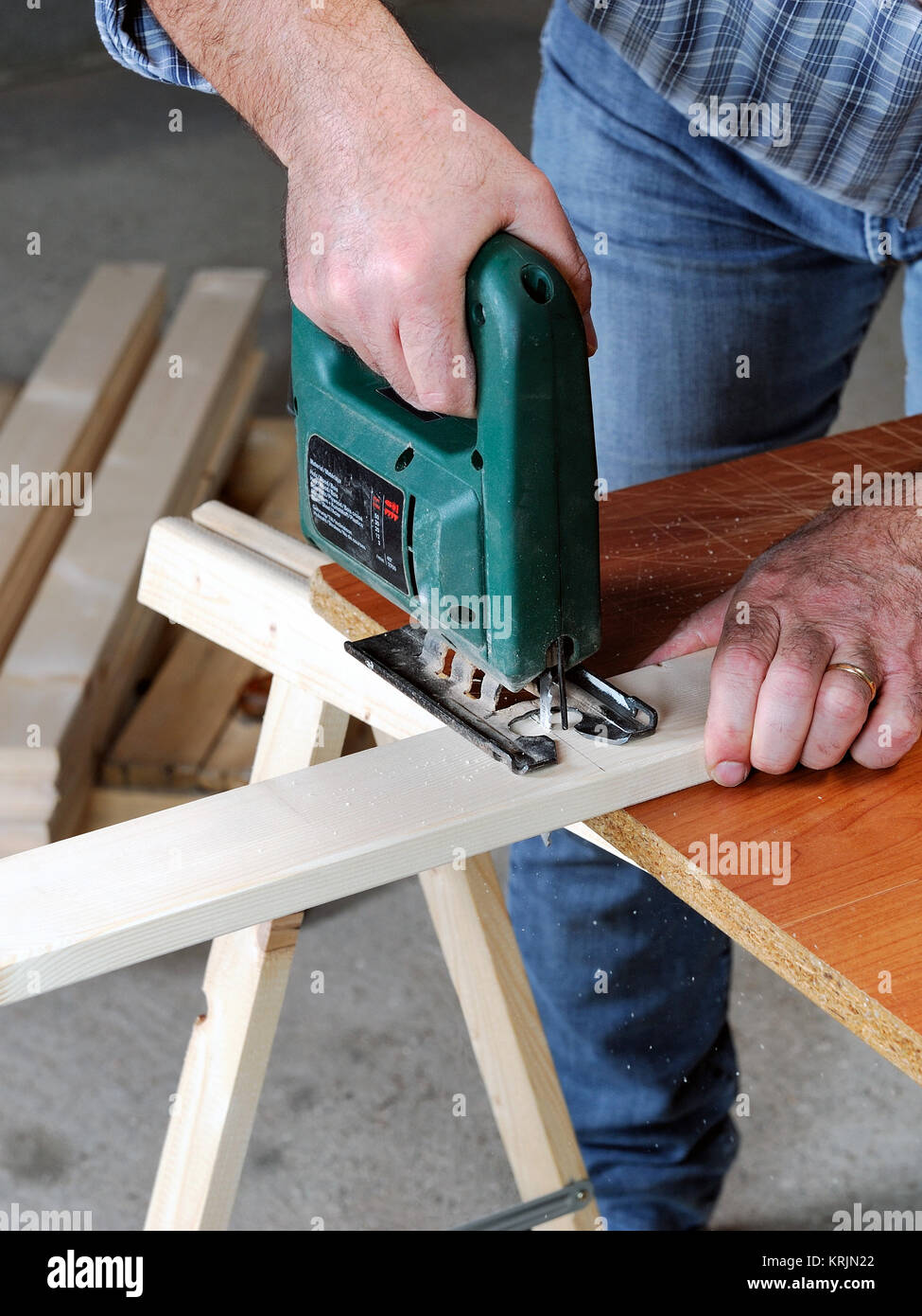 Adult artisan performs cutting with an electric saw of a strip of wood ...