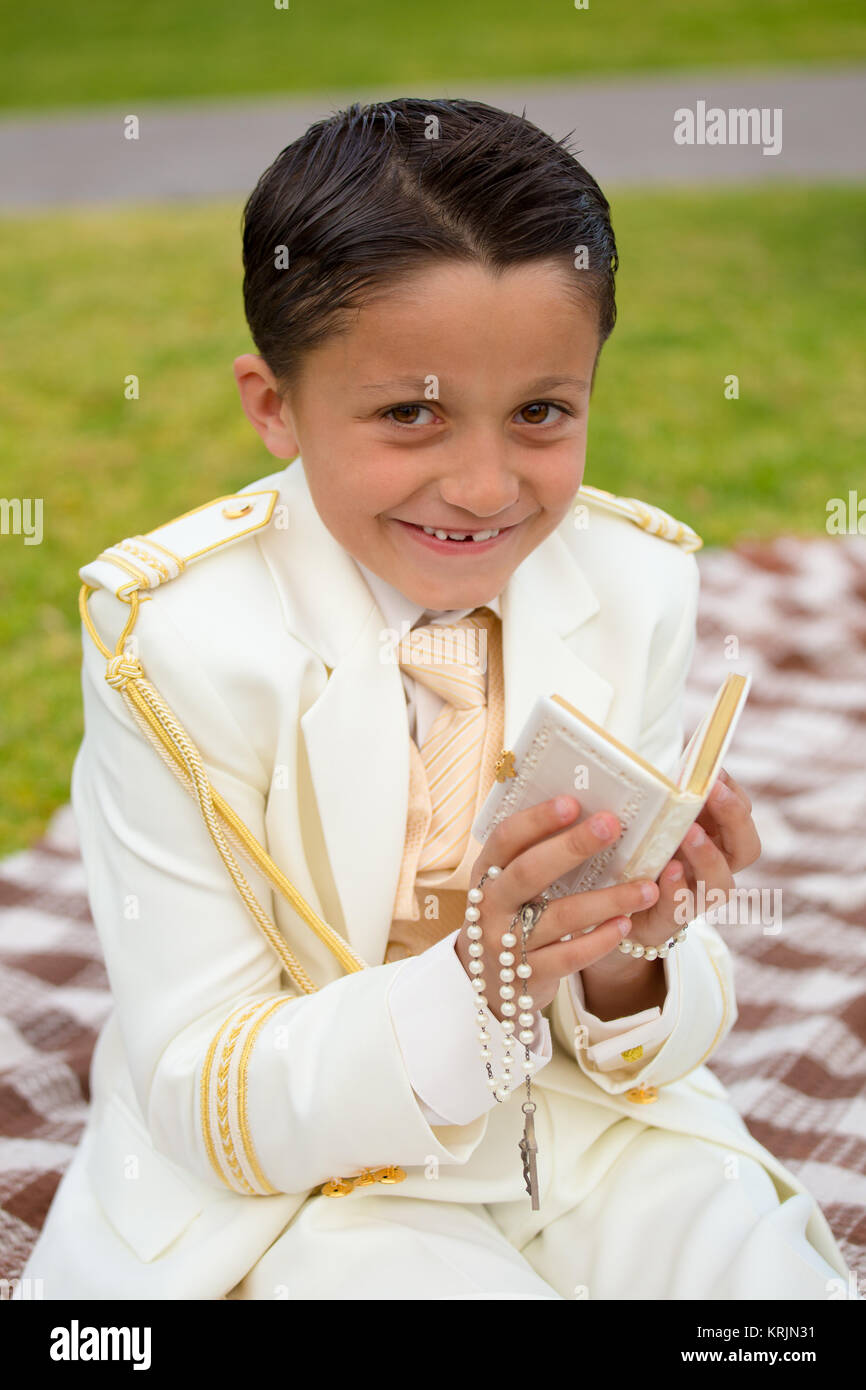 Young First Communion boy smiling with prayer book and rosary Stock ...