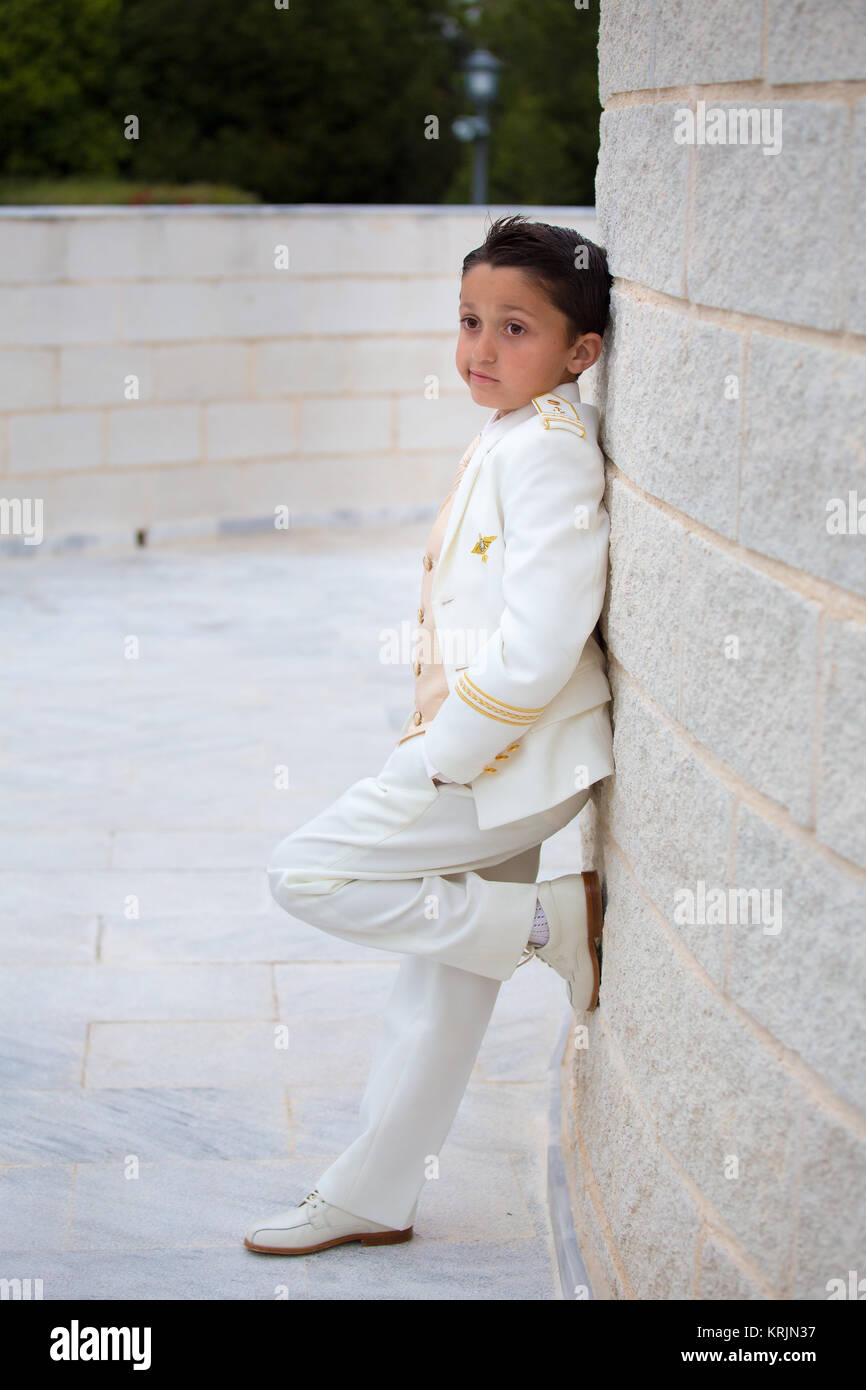 Young First Communion boy leaning on a wall with one foot Stock Photo ...