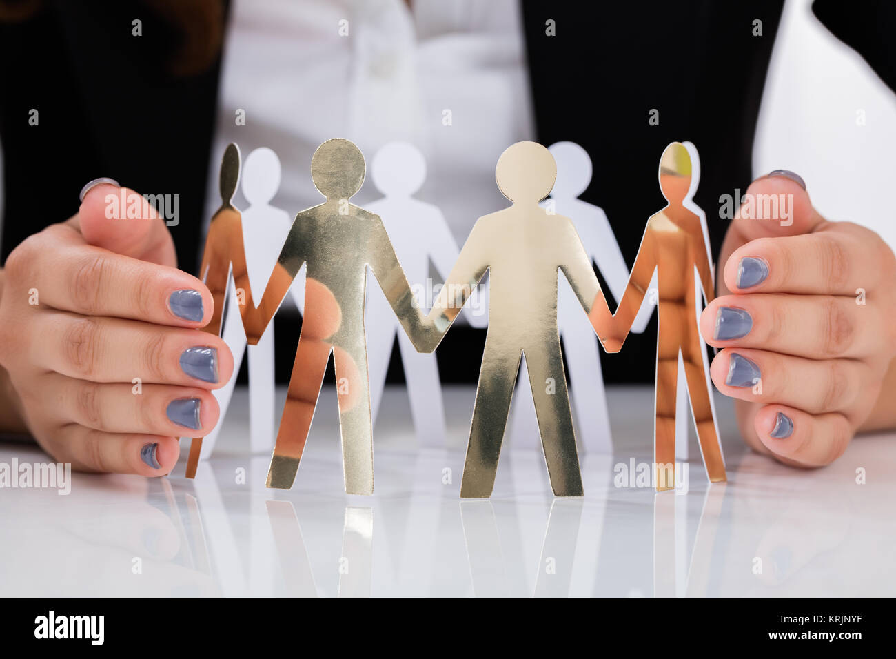 Businesswoman Hand Protecting Cut-out Figures Stock Photo - Alamy