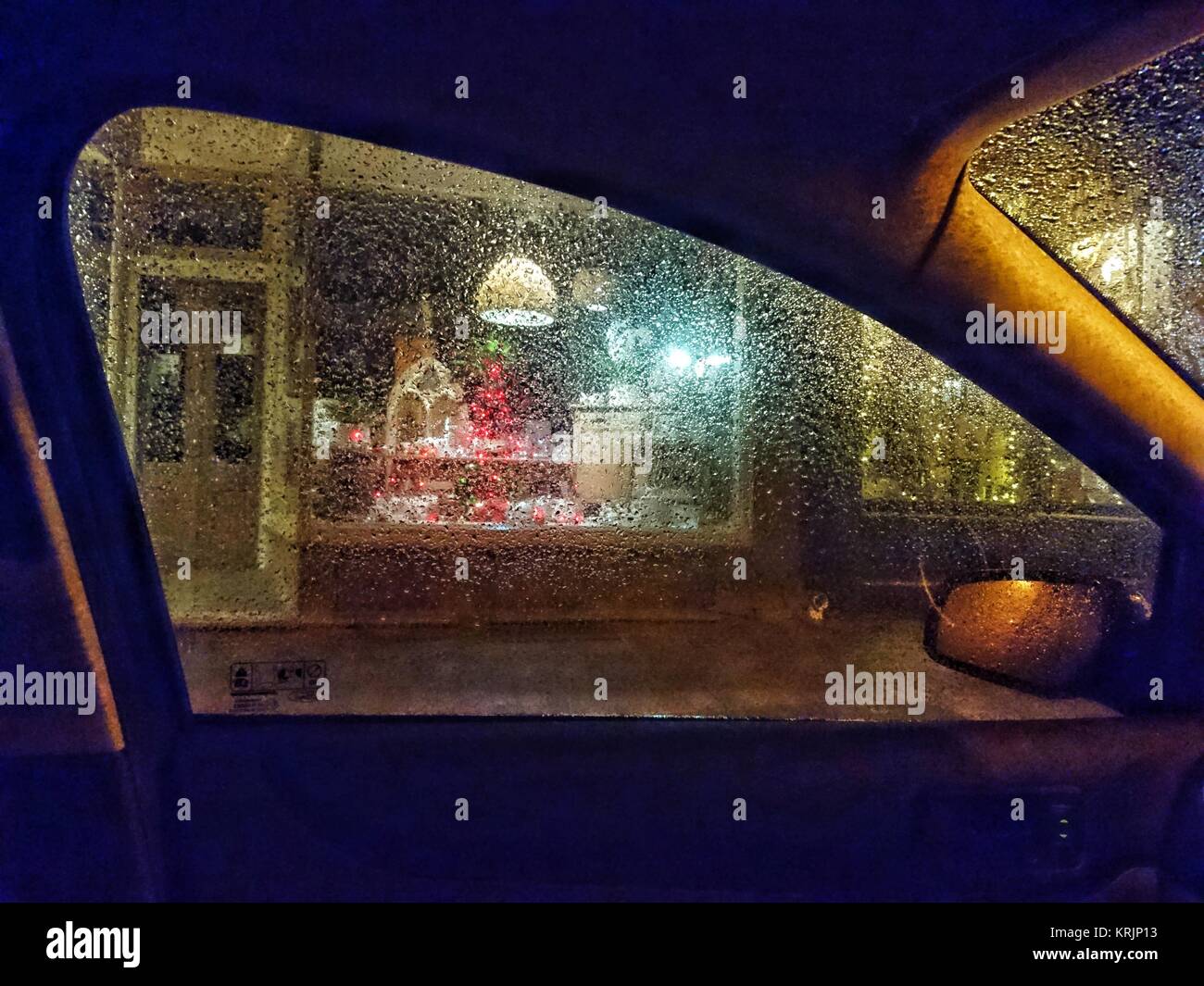Colourful illuminated shop window display at night seen through car ...