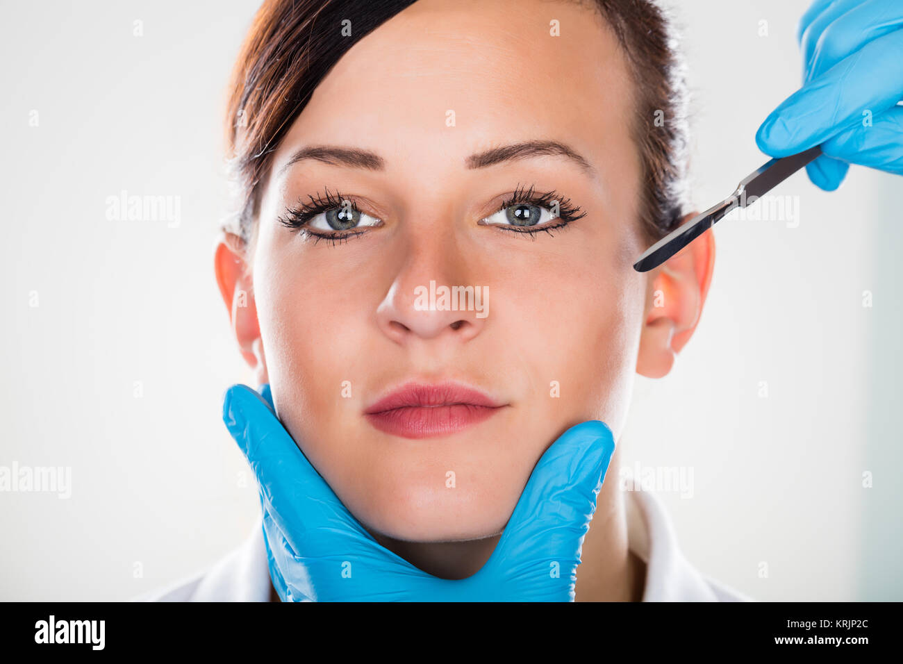 Surgeon's Hand With Scalpel Near Woman's Face Stock Photo - Alamy