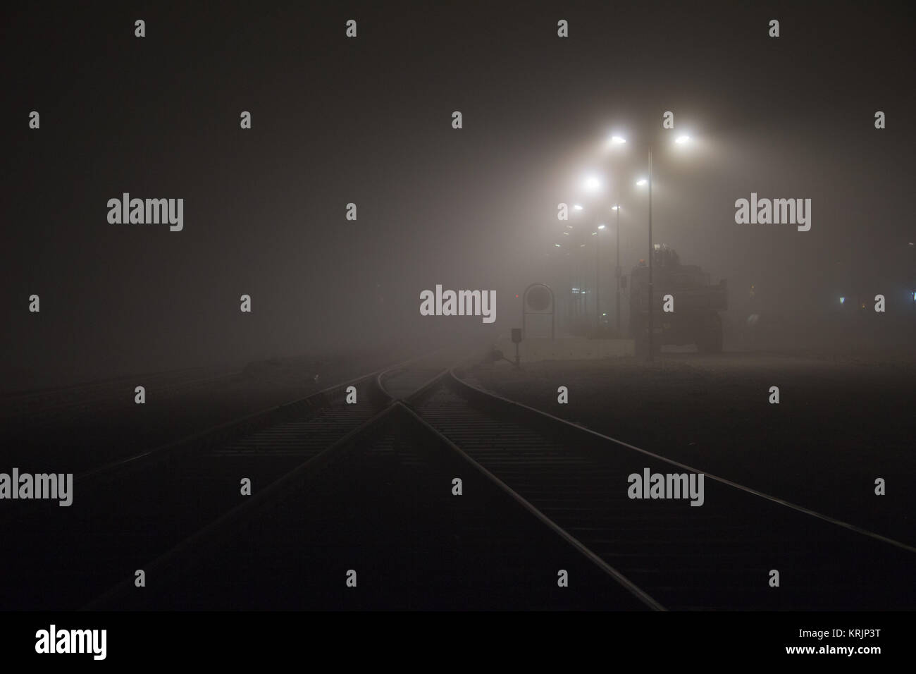light signals near a train station in the fog with artificial lighting ...