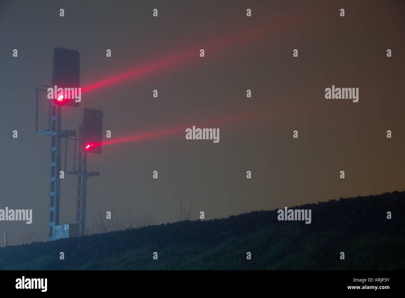 light signals near a train station in the fog with artificial lighting ...