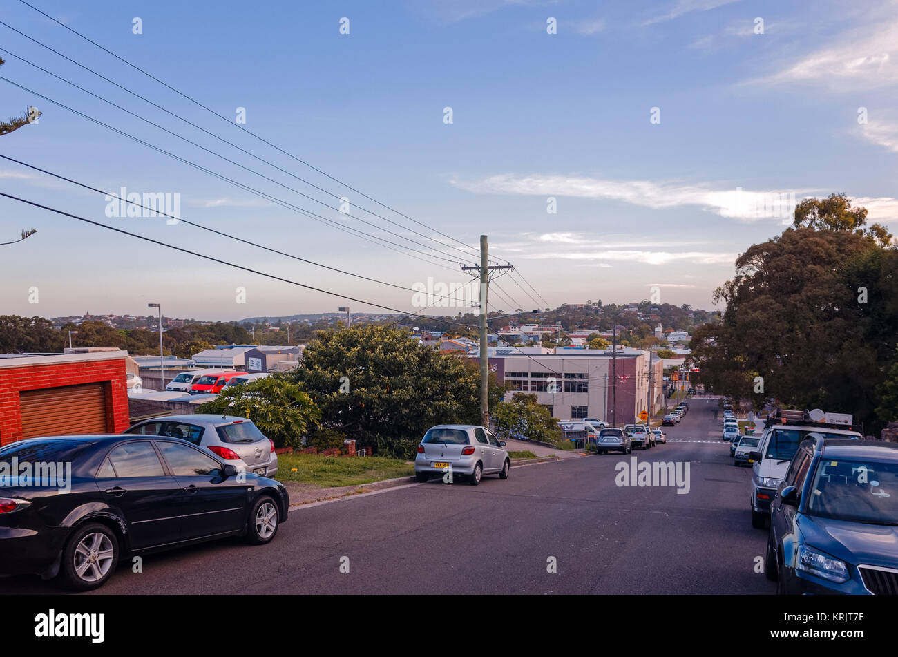 Suburban Australia street with industrial buildings, vehicles and trees ...