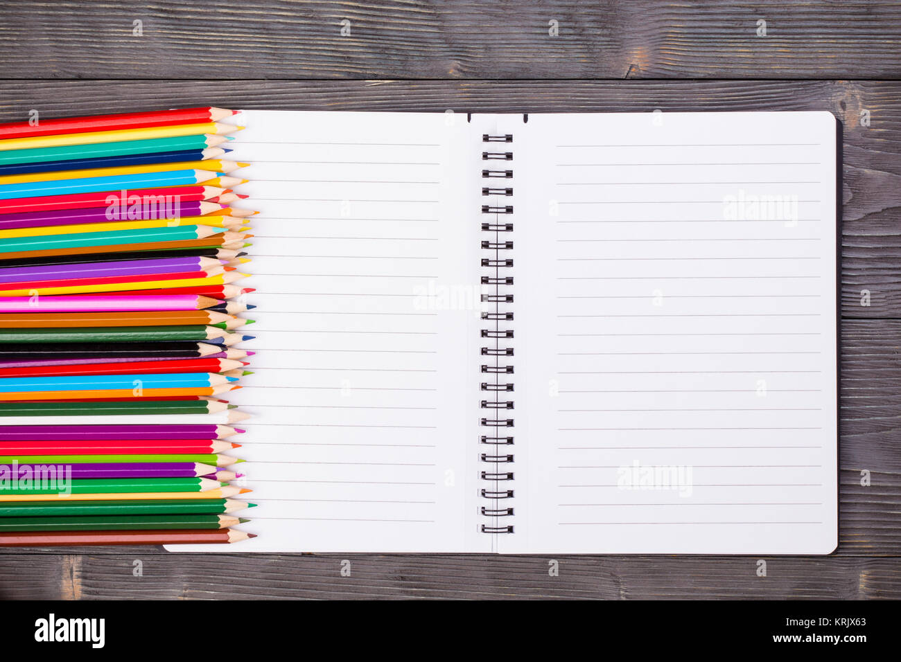 Bunch of color pencils and open notebook Stock Photo - Alamy