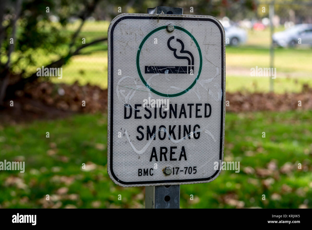 Designated smoking sign in a city park Stock Photo - Alamy