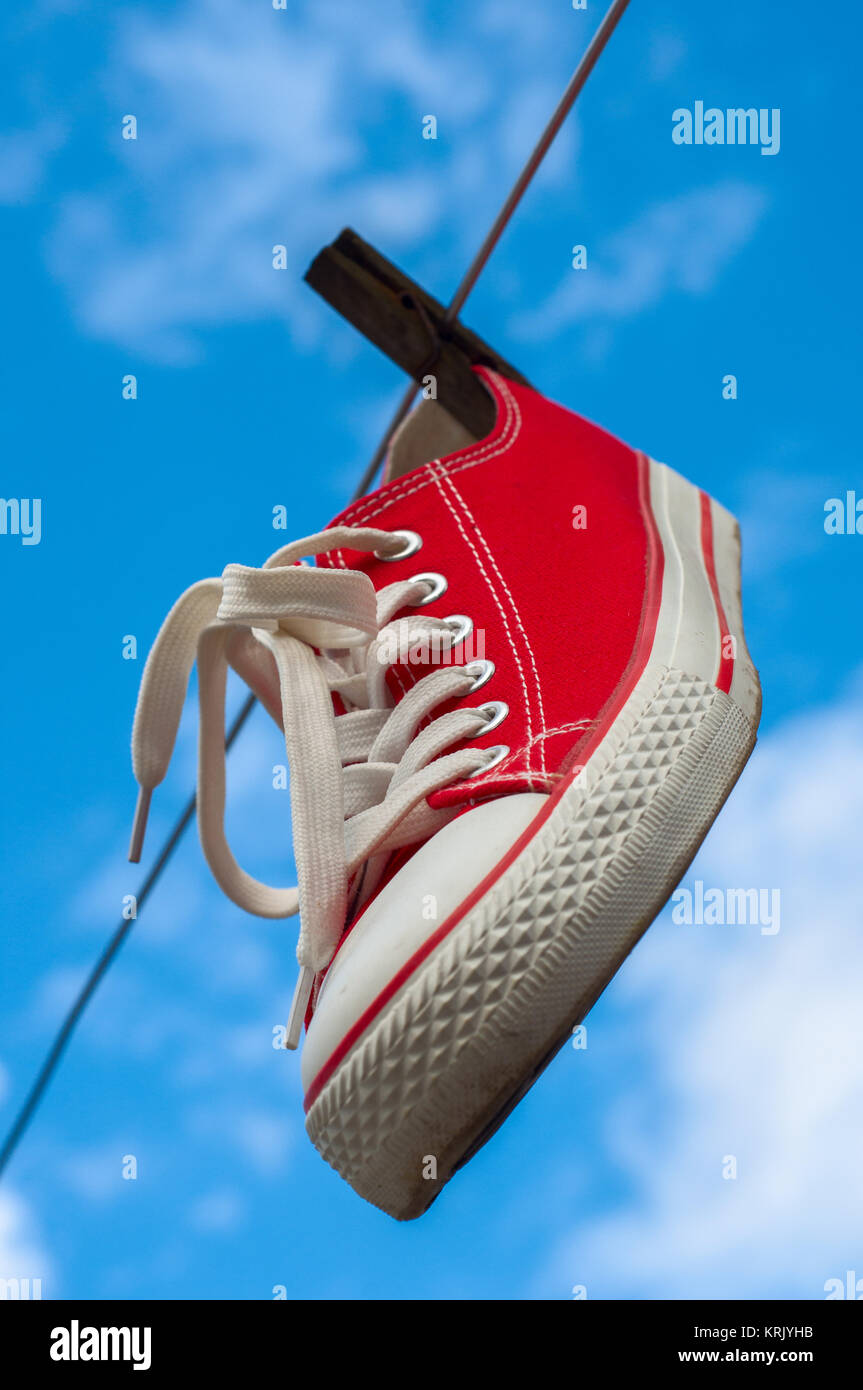 One red sneakers hanging on a clothesline against a blue sky Stock ...