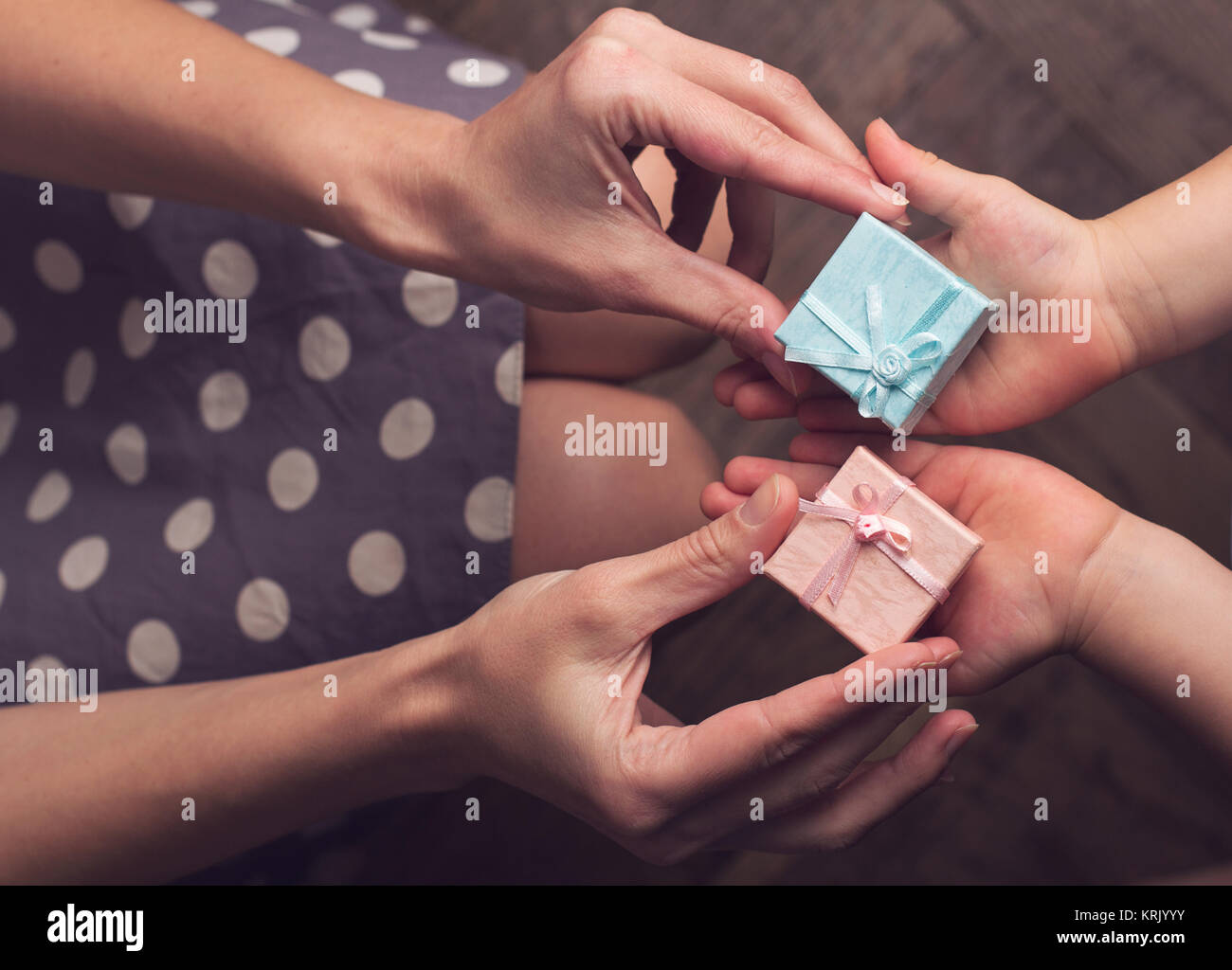 Mother giving two small gift boxes to her kid with open hand Stock ...