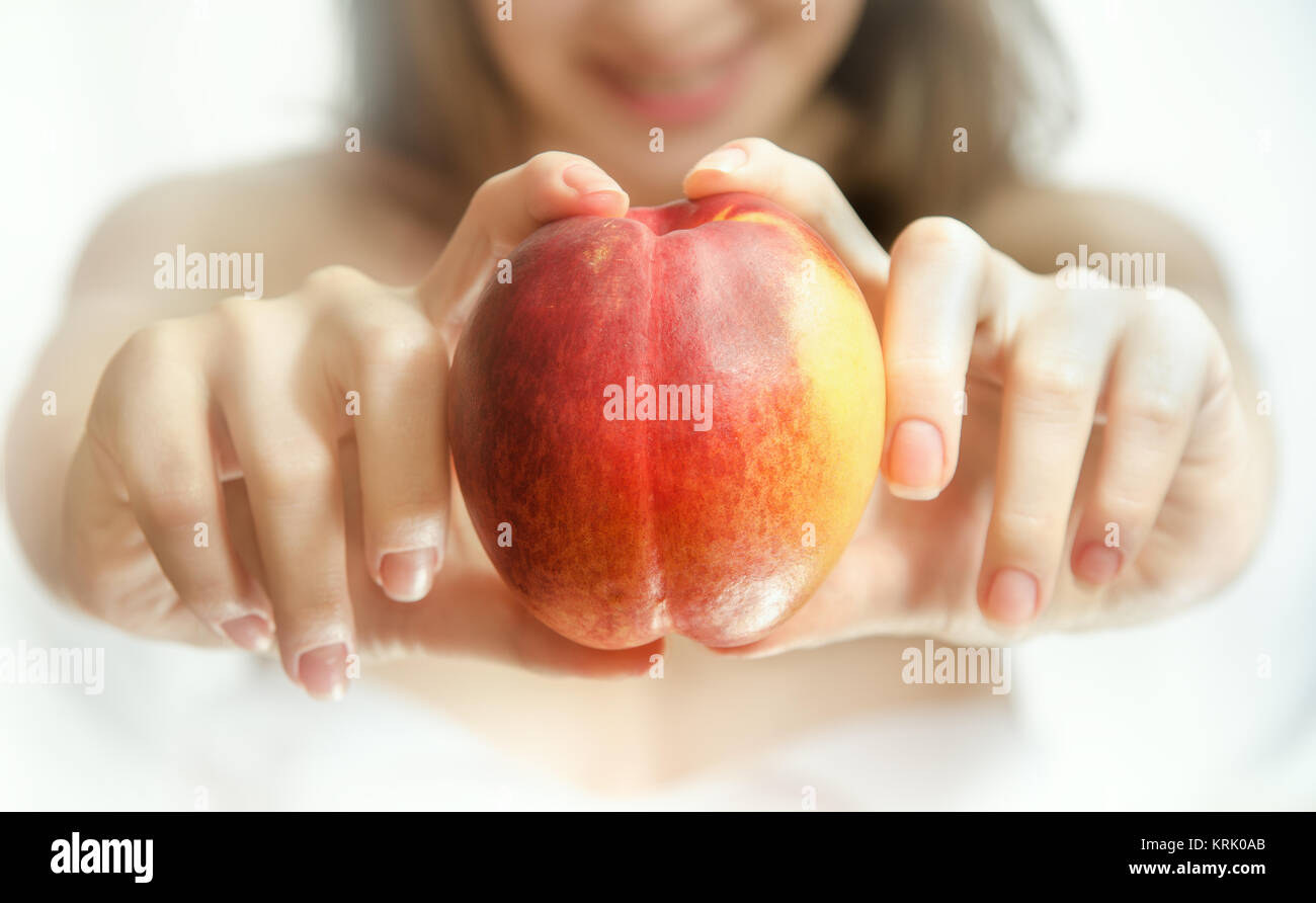 Peach in female hands Stock Photo - Alamy