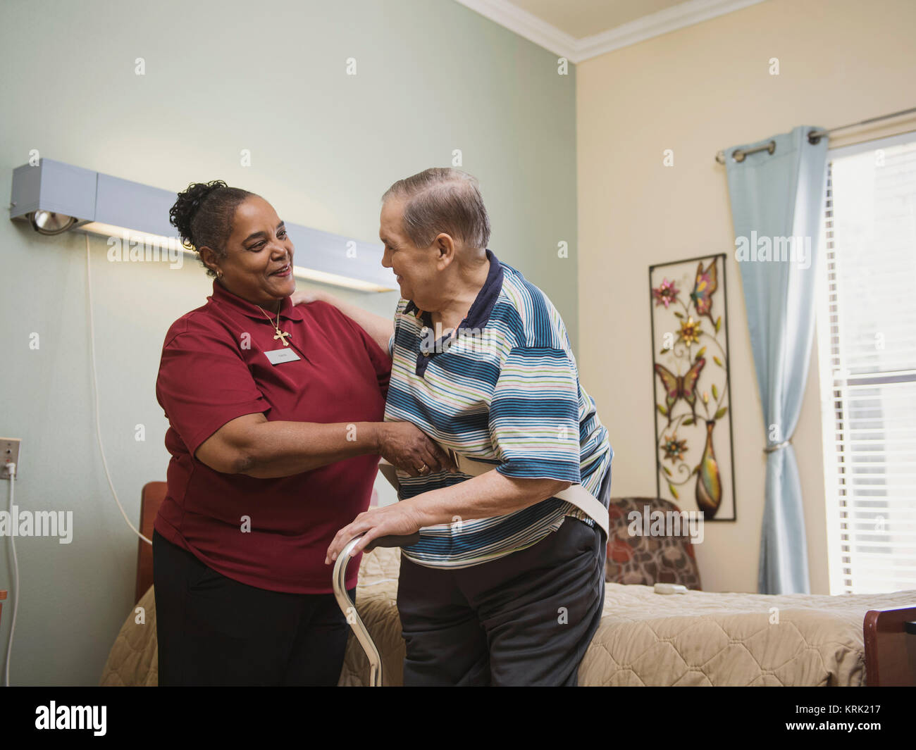 Nurse helping man using cane Stock Photo - Alamy