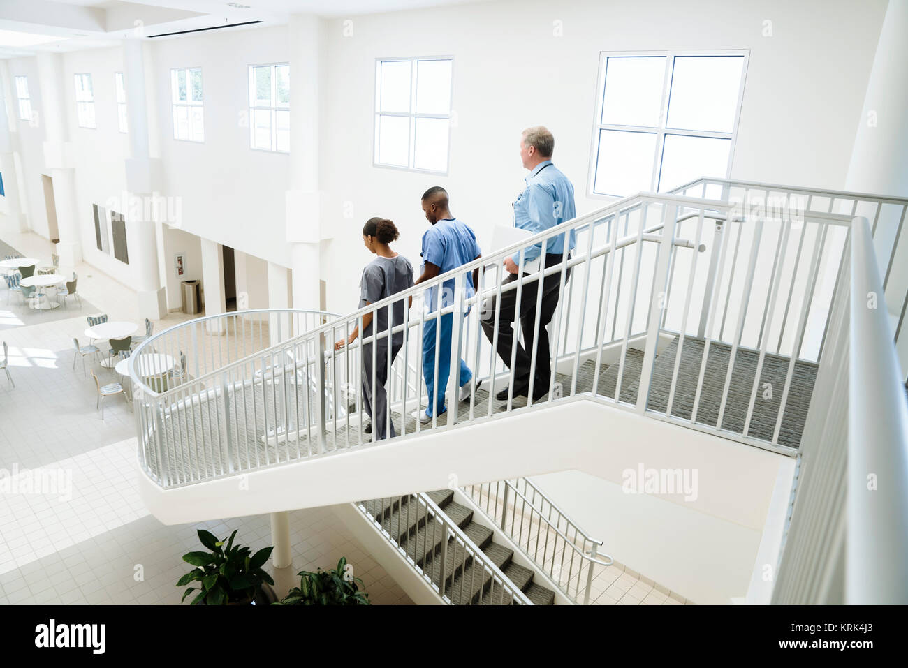 Doctor and nurses descending staircase Stock Photo - Alamy