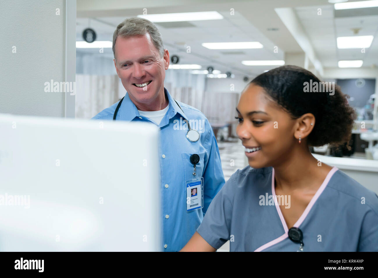 Smiling doctor and nurse using computer Stock Photo - Alamy