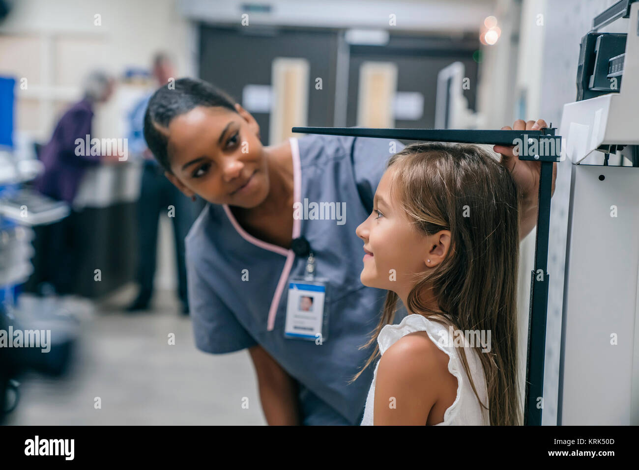 Nurse measuring height of girl Stock Photo - Alamy
