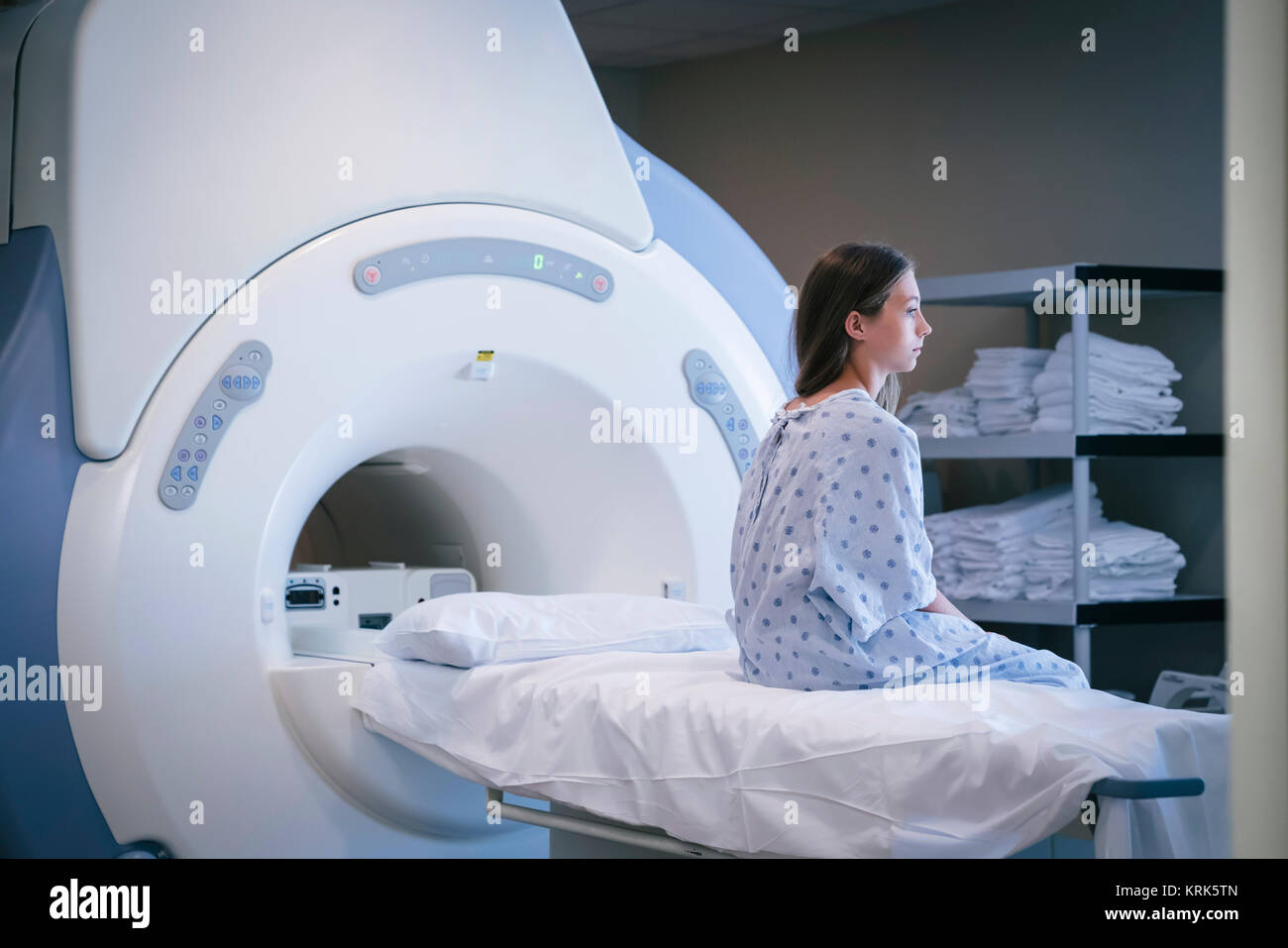 Pensive Caucasian girl sitting on scanner table Stock Photo - Alamy
