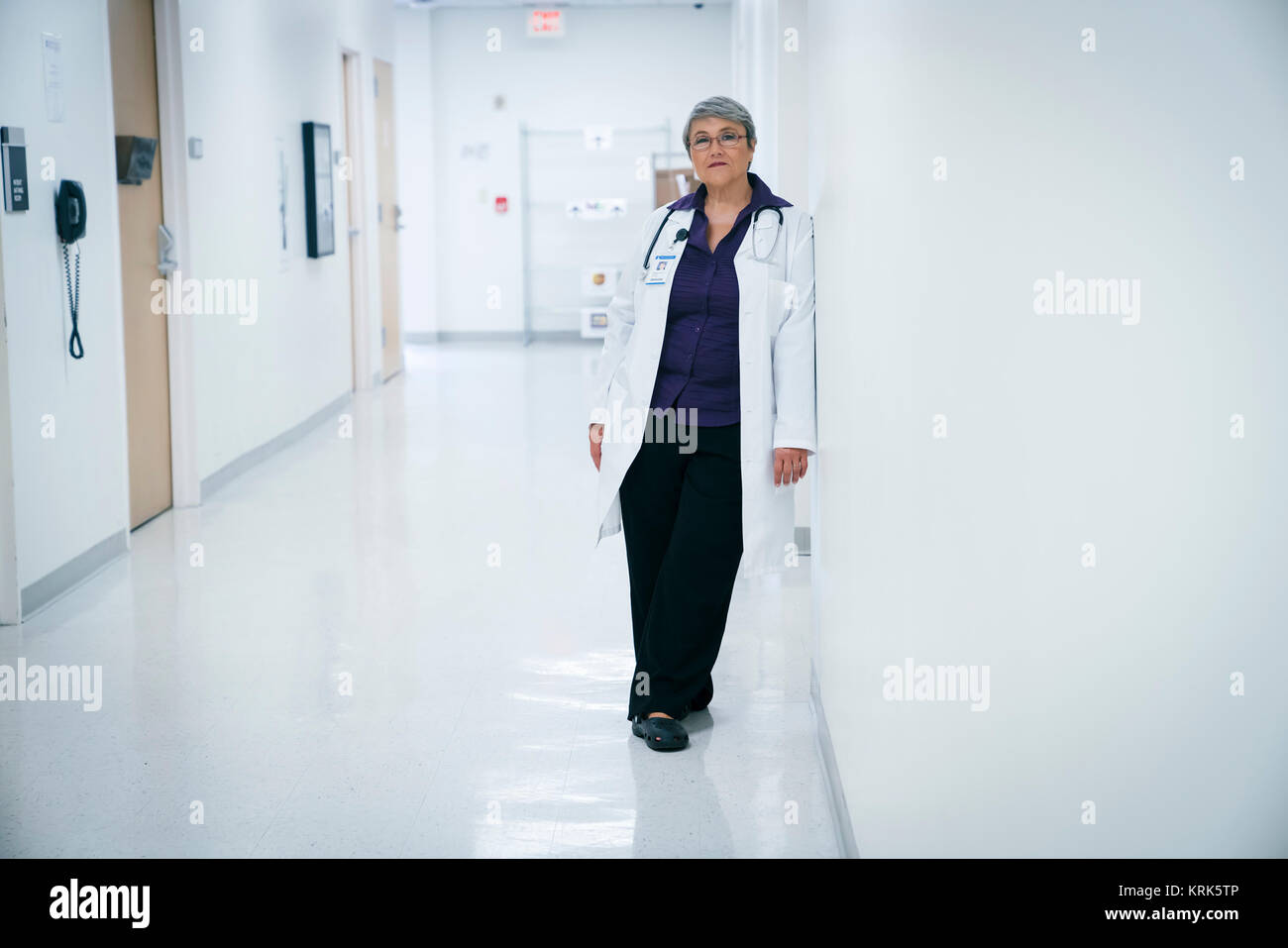 Mixed race doctor leaning on hospital wall Stock Photo - Alamy