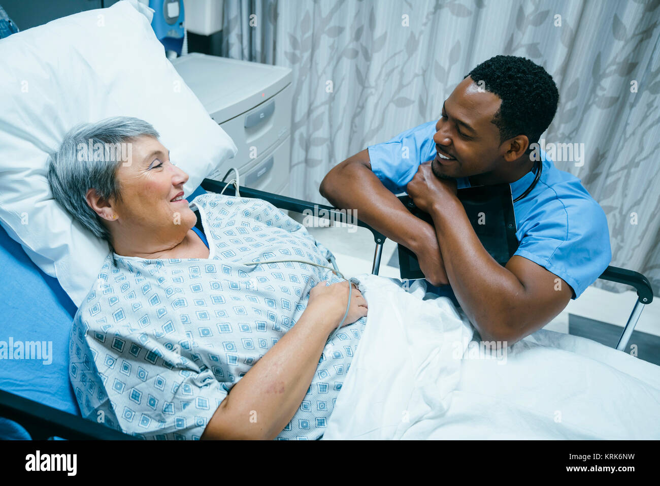 Nurse talking to patient in hospital bed Stock Photo - Alamy