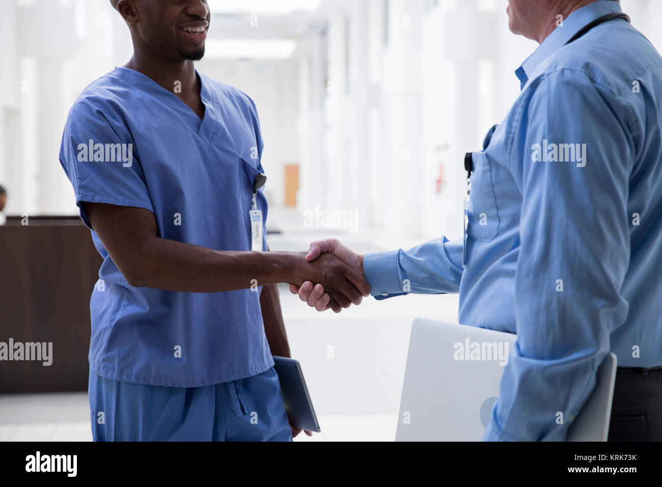 Close up of doctor and nurse shaking hands Stock Photo - Alamy
