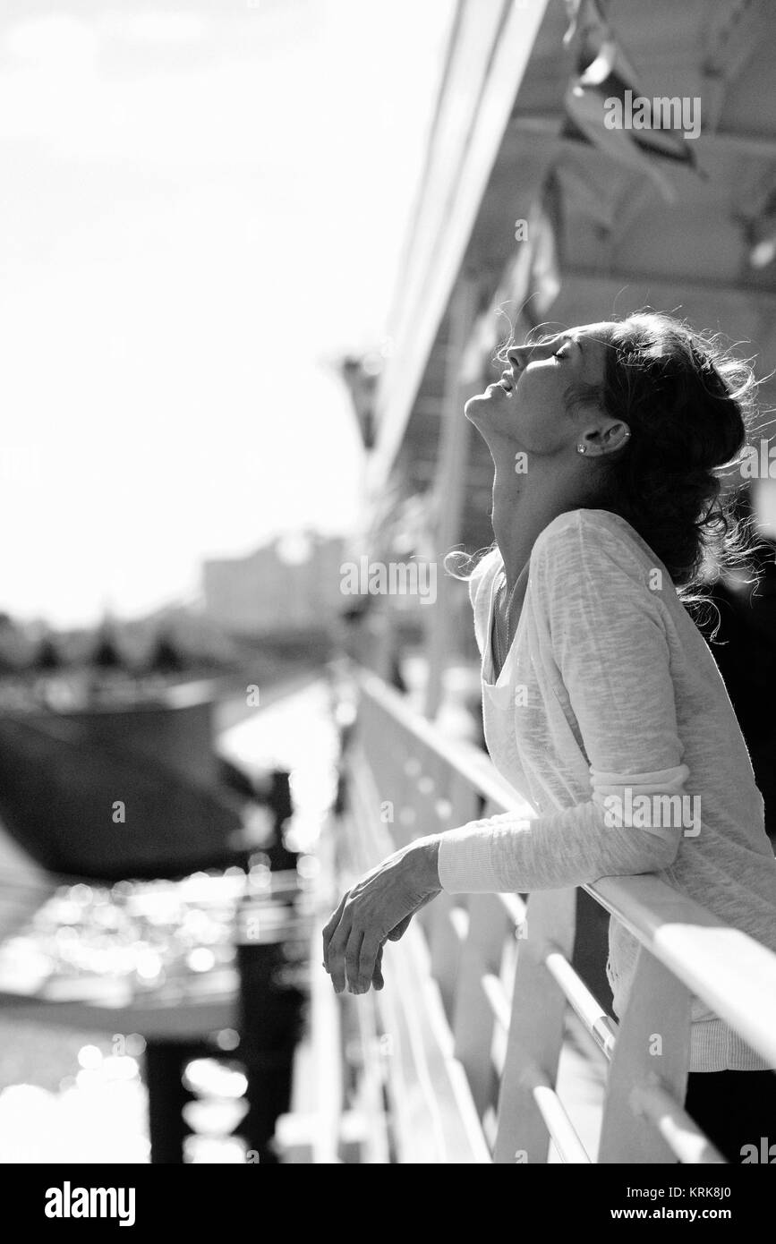 Caucasian woman relaxing and leaning on railing Stock Photo - Alamy
