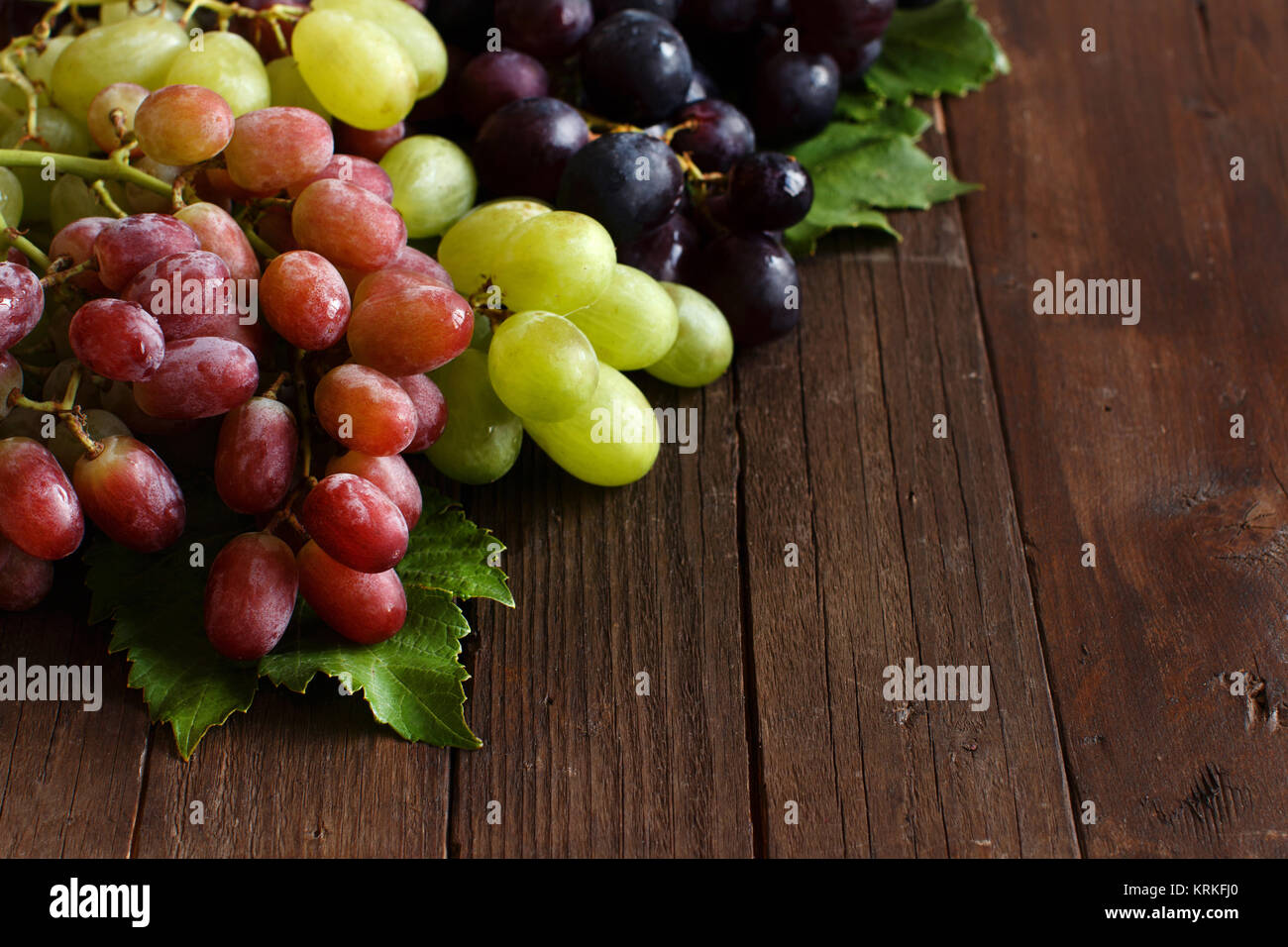 Three types of grapes on a wooden Background Stock Photo - Alamy