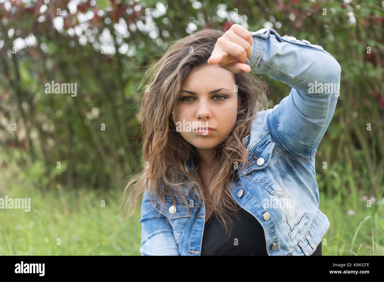 Teenage girl makes the hand gesture staring at the camera Stock Photo ...