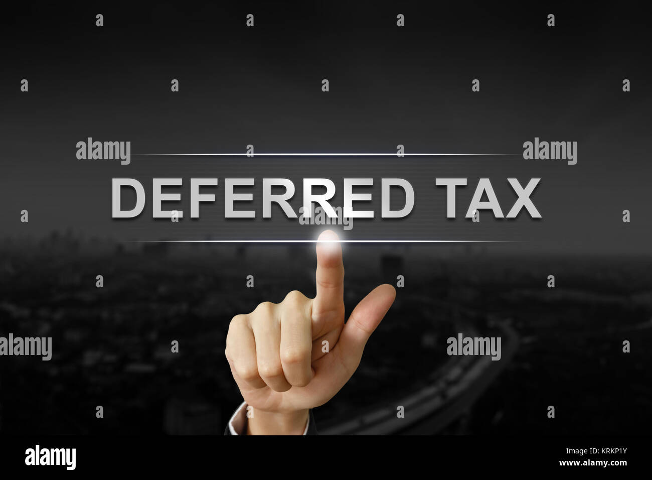business hand pushing deferred tax button on black blurred background ...