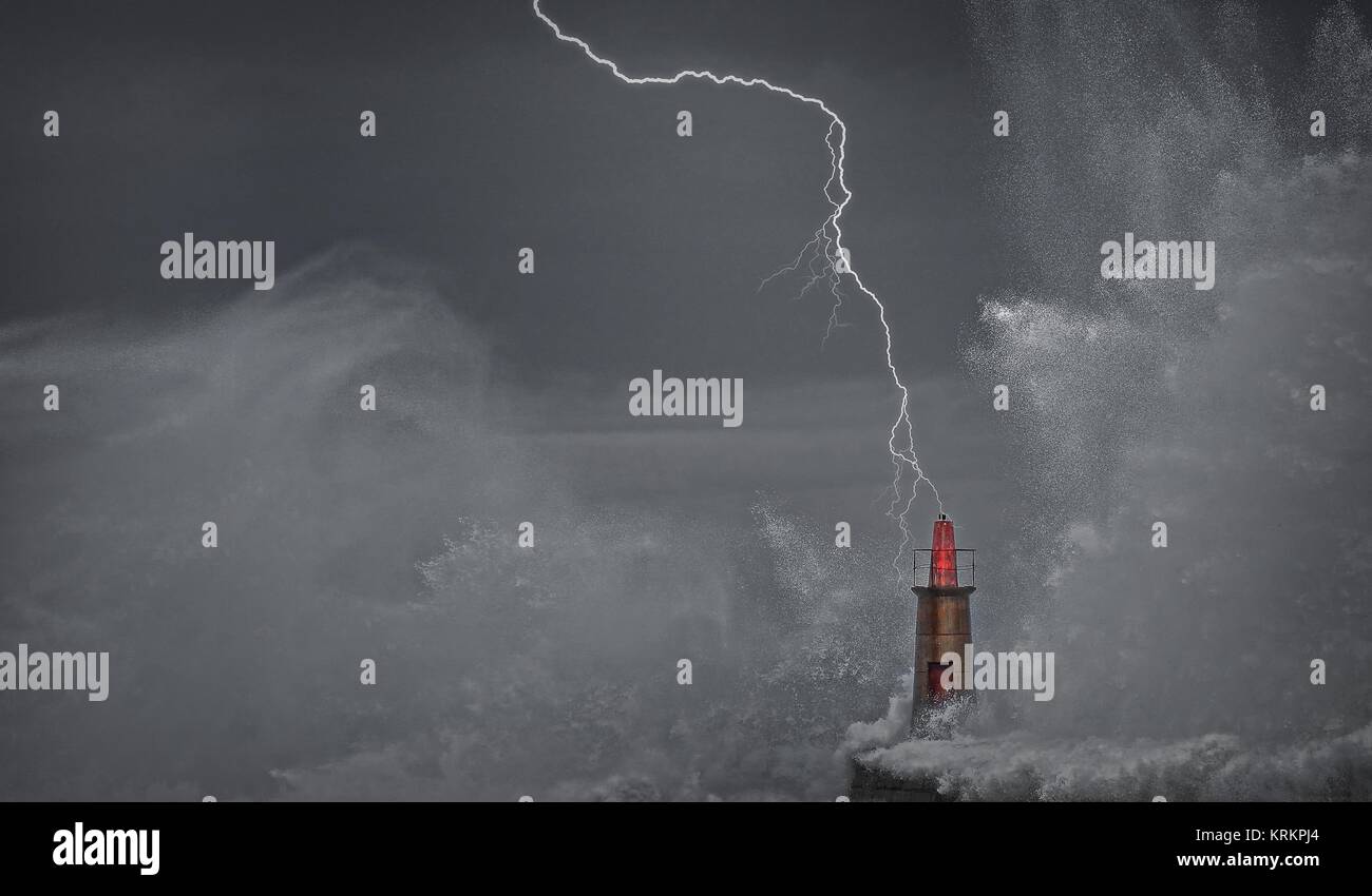 Lightning and wave over old lighthouse and pier of Viavelez in Asturias ...