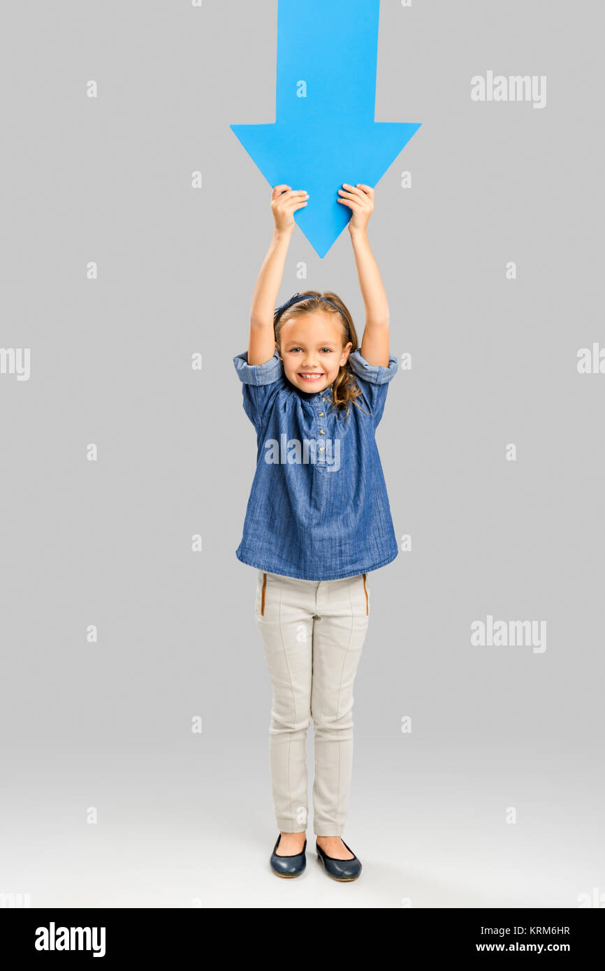 Girl holding a big blue arrow Stock Photo - Alamy