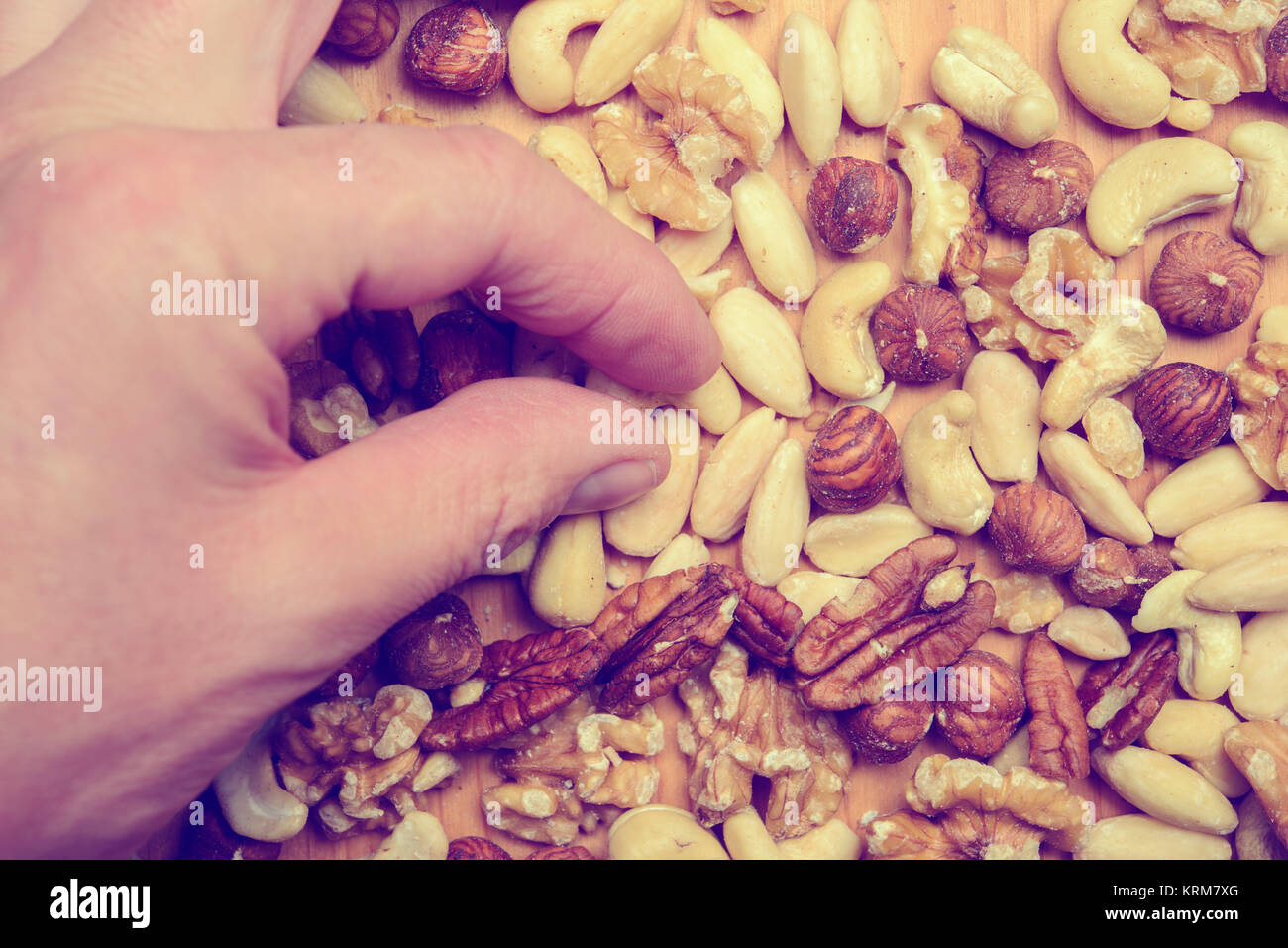 hand with different nuts on wooden ground from above Stock Photo - Alamy