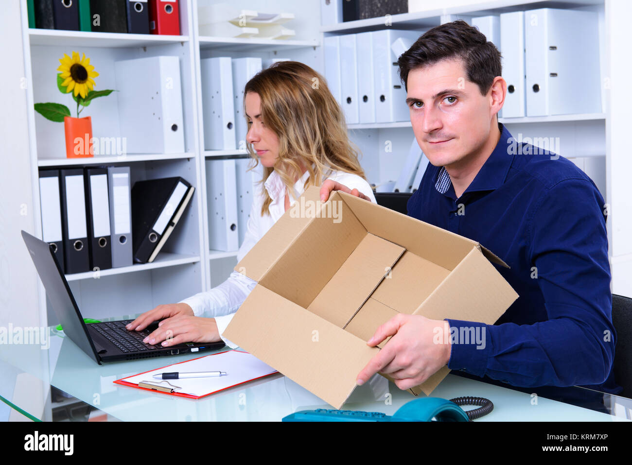 young businessman and businesswoman with empty delivery box in the ...
