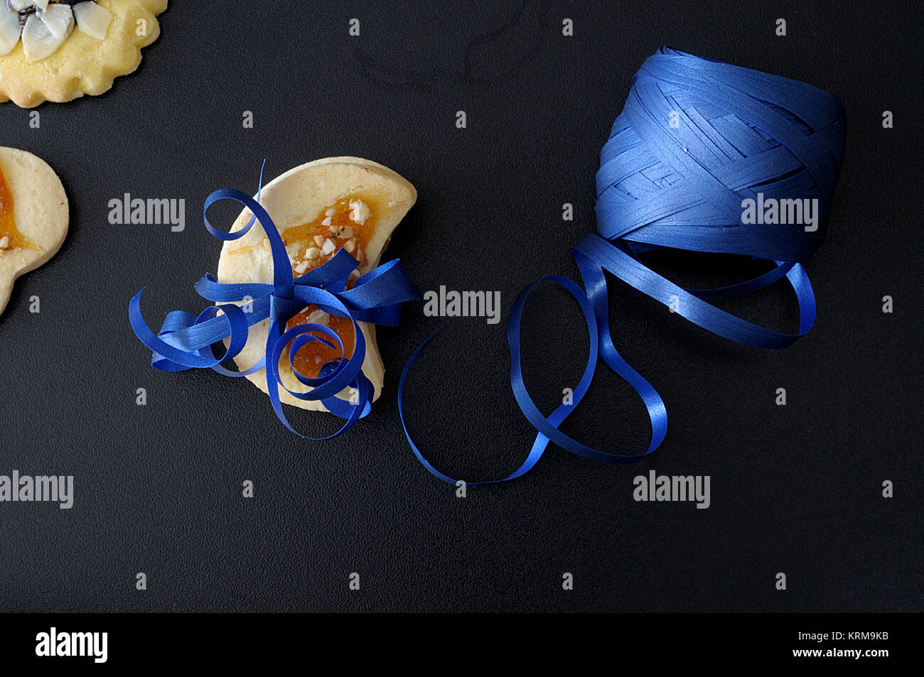 Shortbread biscuits, tied with a blue ribbon, on black background ...