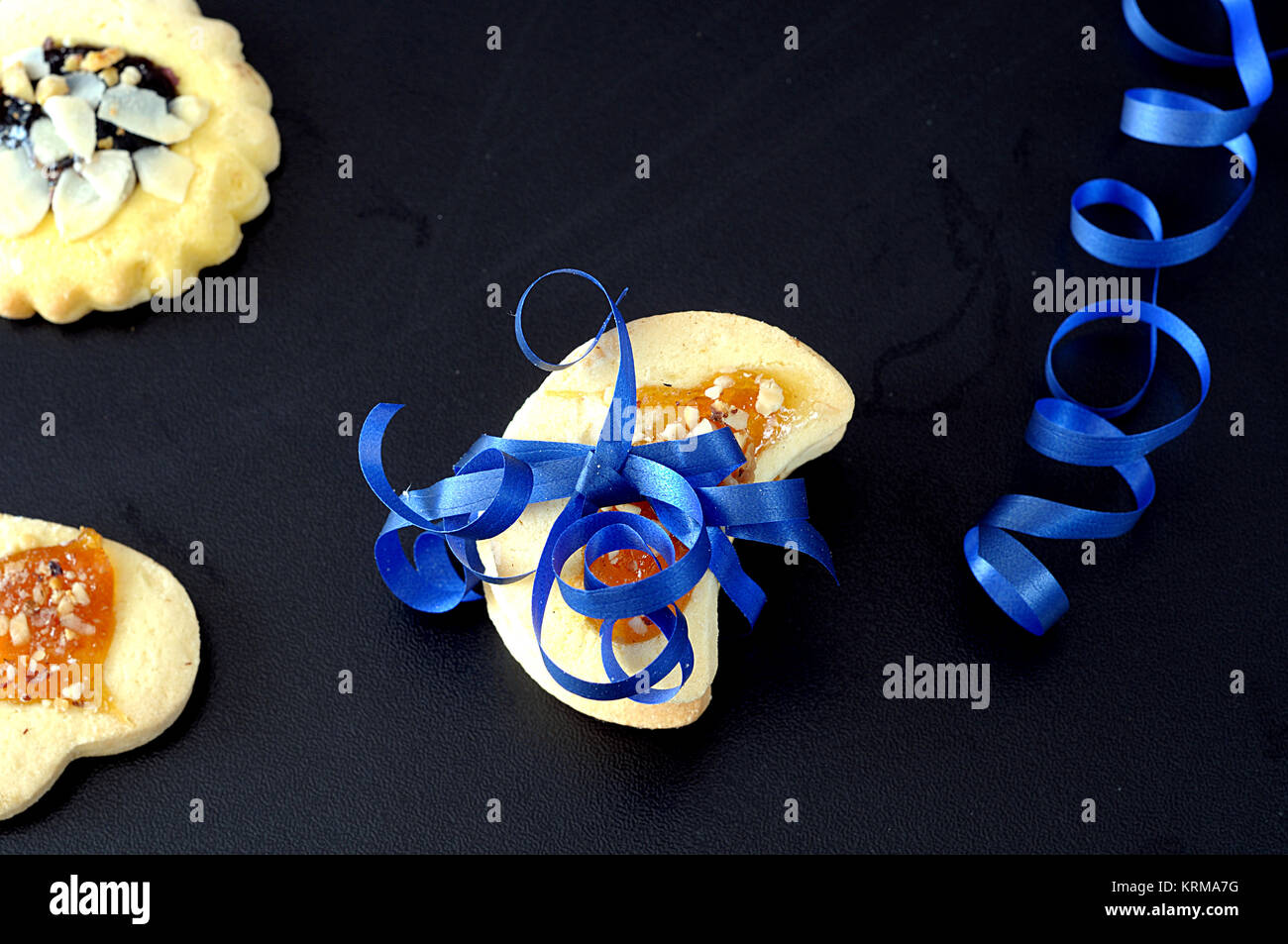 Biscuit tied with blue ribbon on black Stock Photo - Alamy